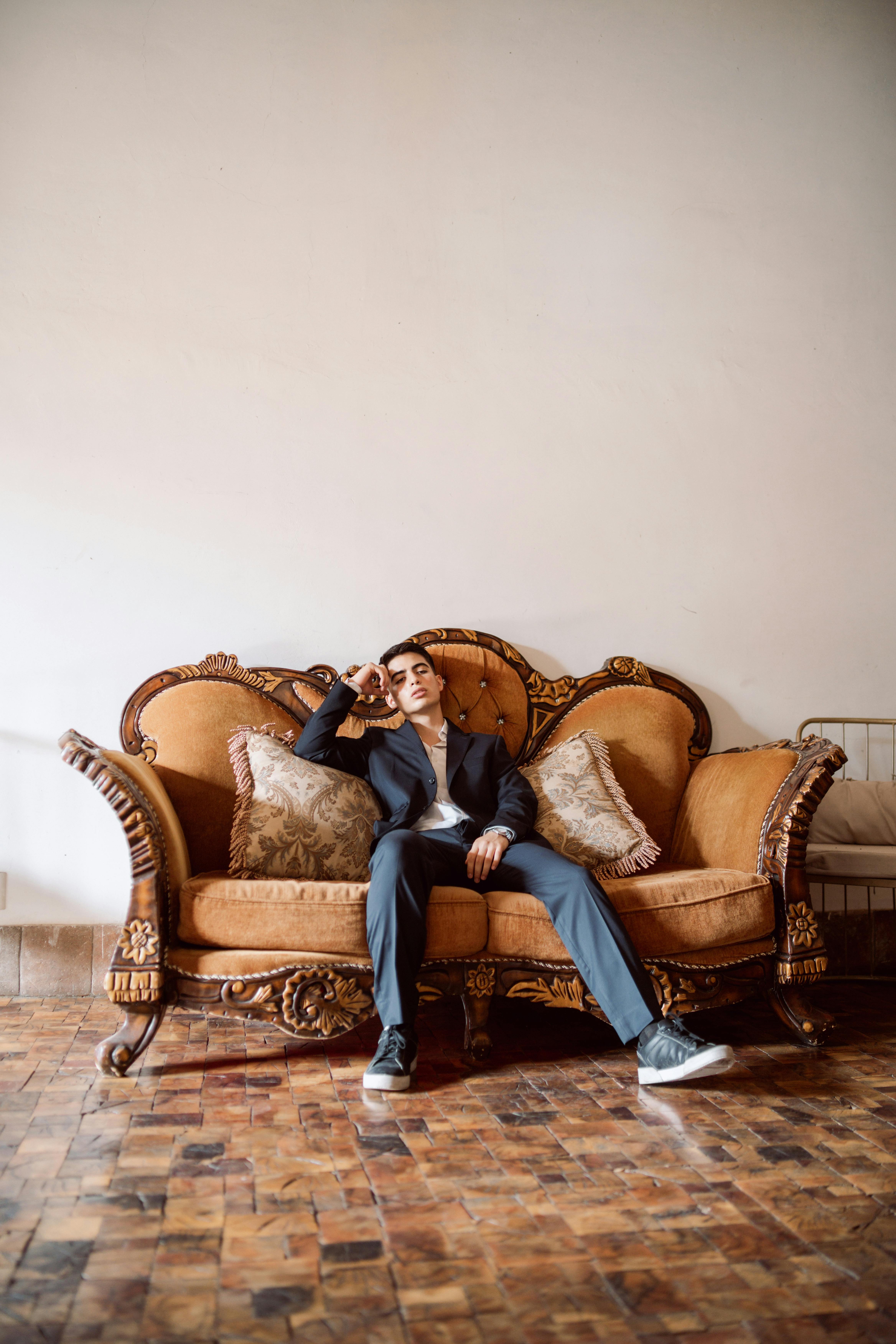 Man in Suit Sitting on Vintage Couch · Free Stock Photo