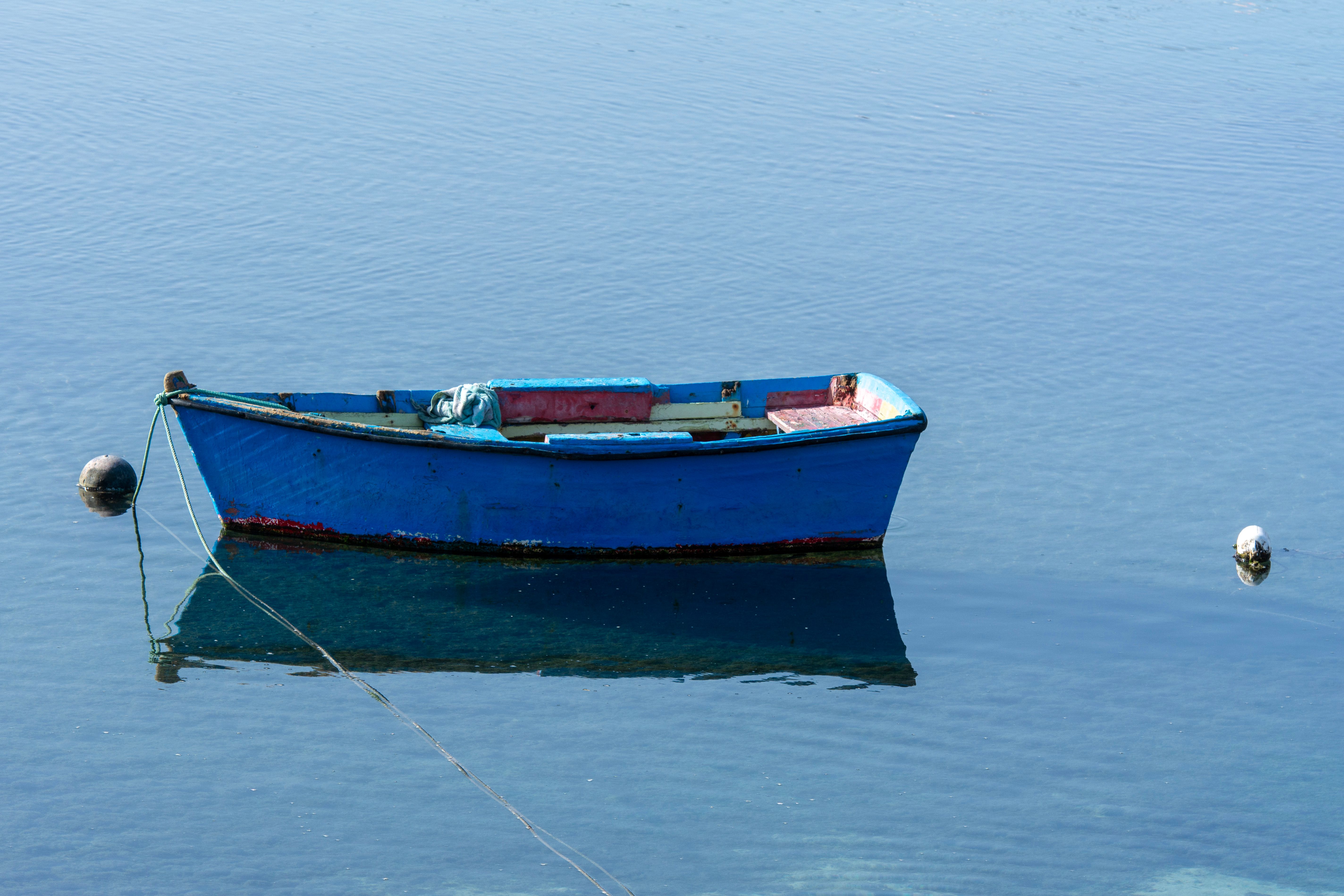 A blue boat floating in the water with a rope · Free Stock Photo