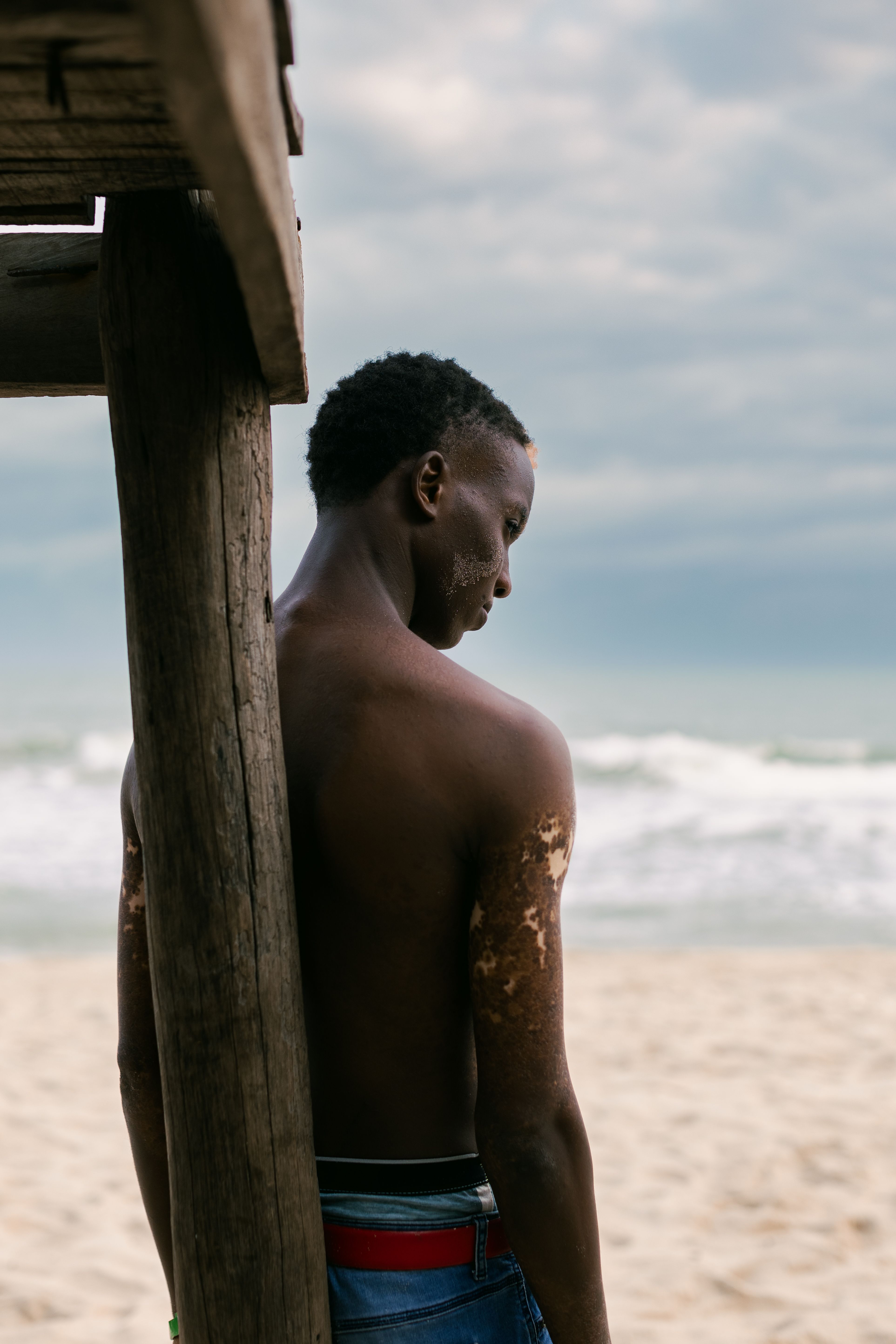 A man standing on the beach with his back to the ocean · Free Stock Photo