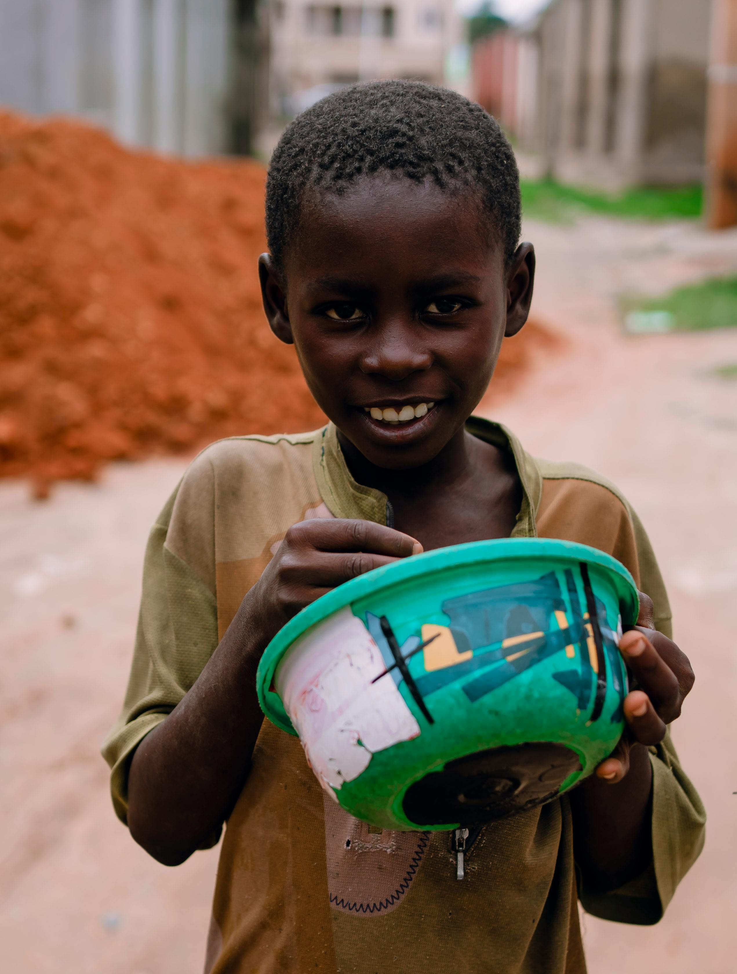 A young boy holding a bowl of food · Free Stock Photo