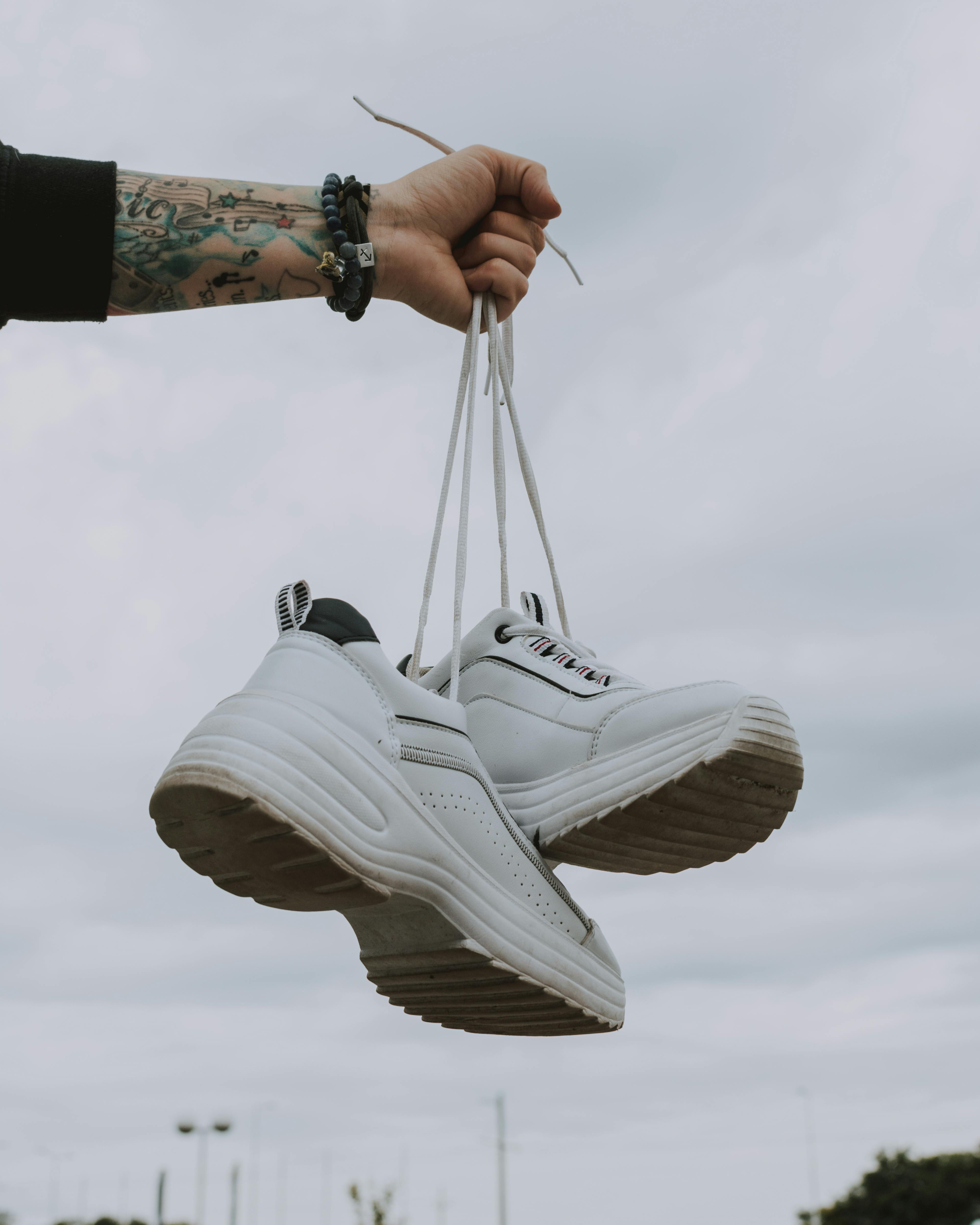 Person Holding White Shoes · Free Stock Photo