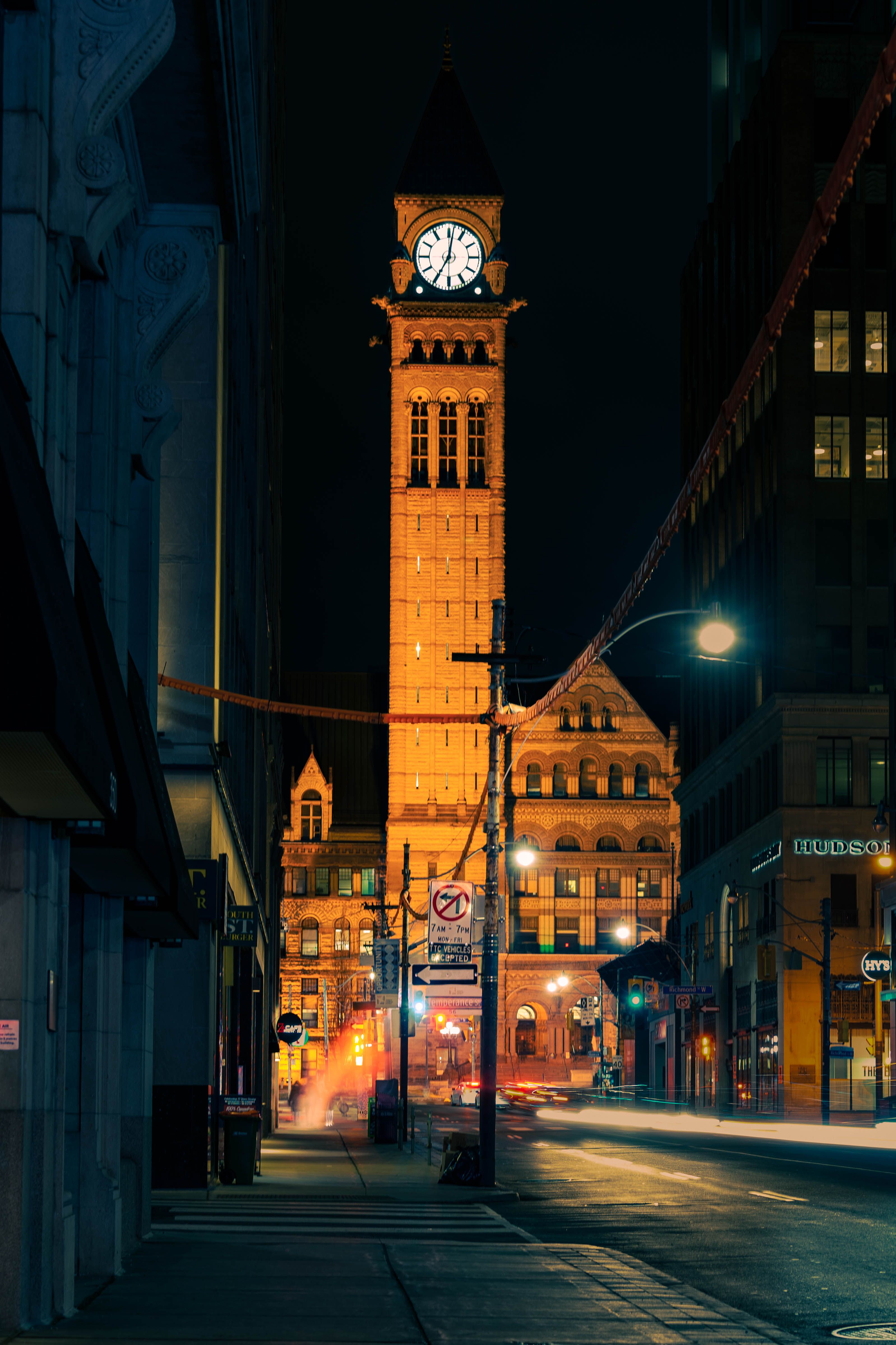 A clock tower is lit up at night · Free Stock Photo