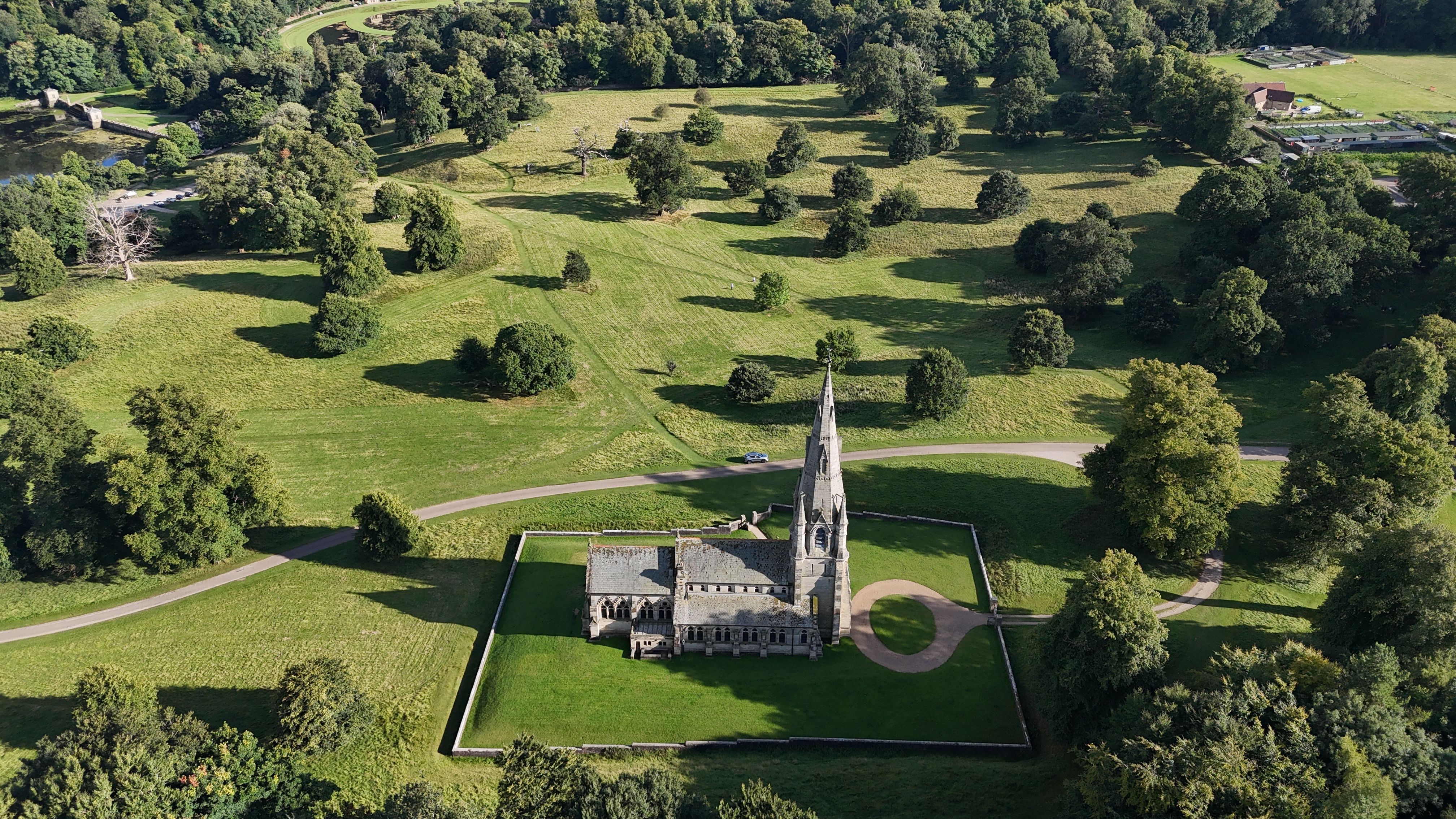Aerial view of a church and surrounding green fields · Free Stock Photo