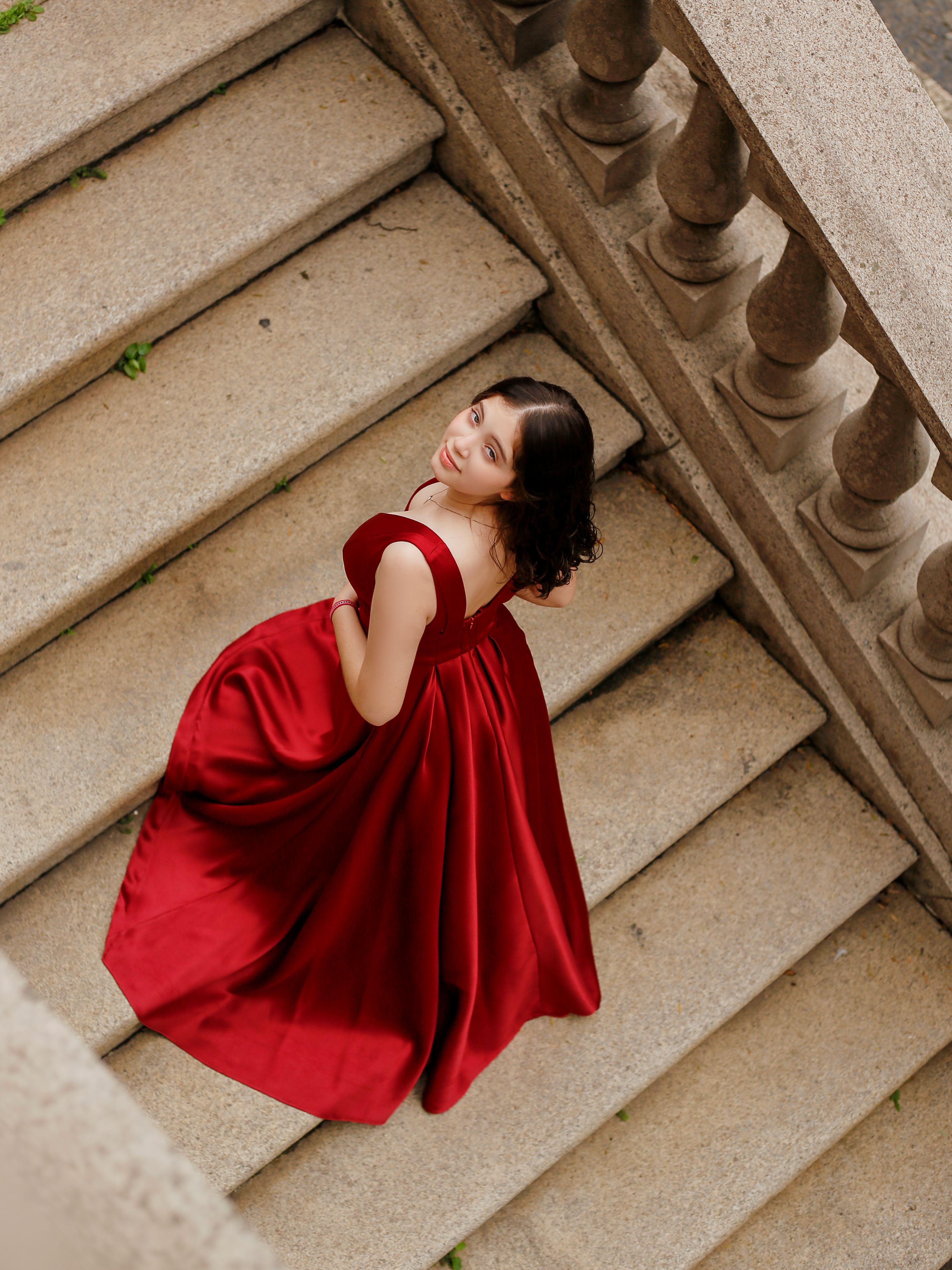 A woman in a red dress is standing on some stairs · Free Stock Photo