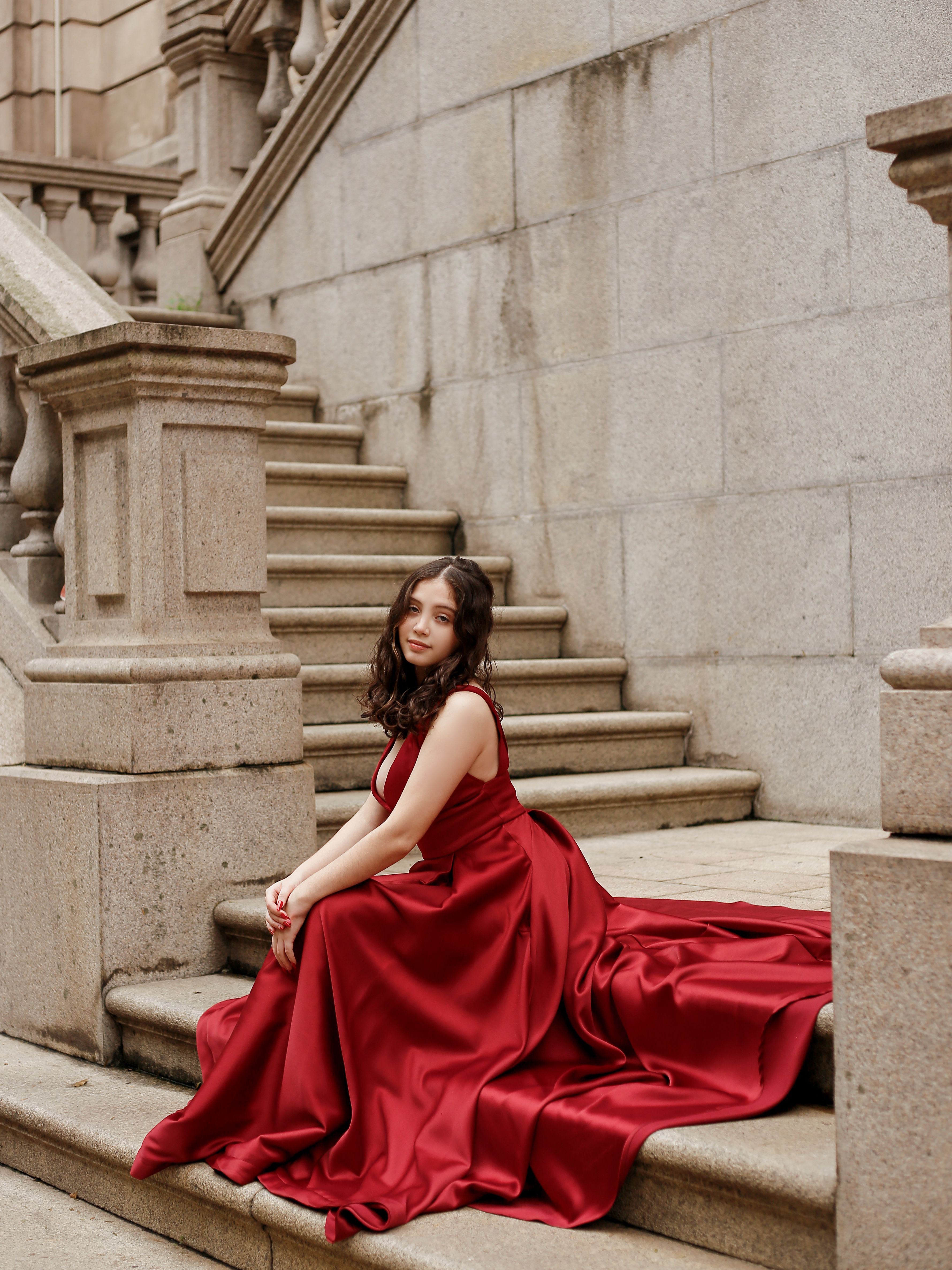 A woman in a red dress sitting on some steps · Free Stock Photo
