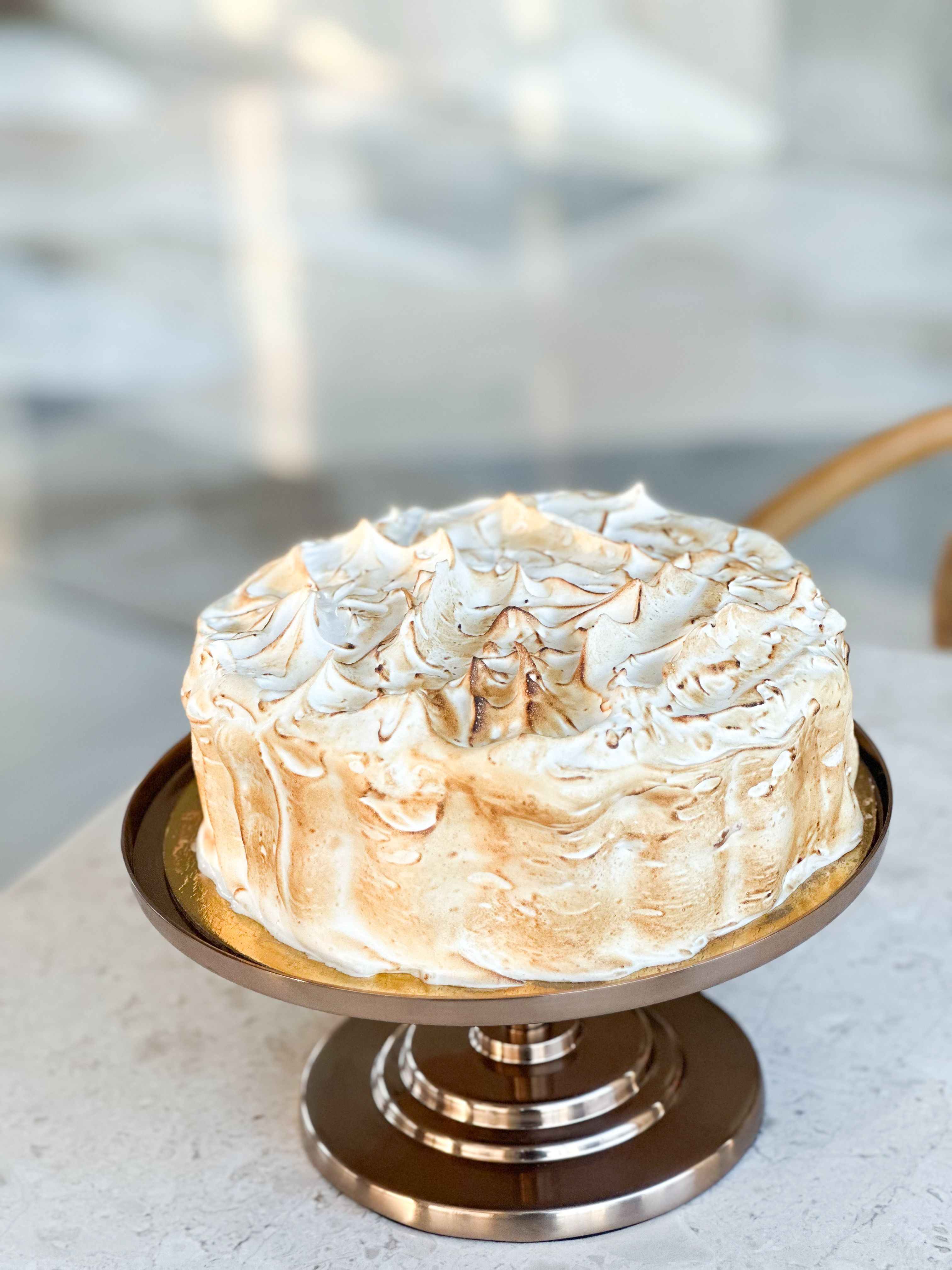 A cake on a metal stand with a meringue on top · Free Stock Photo