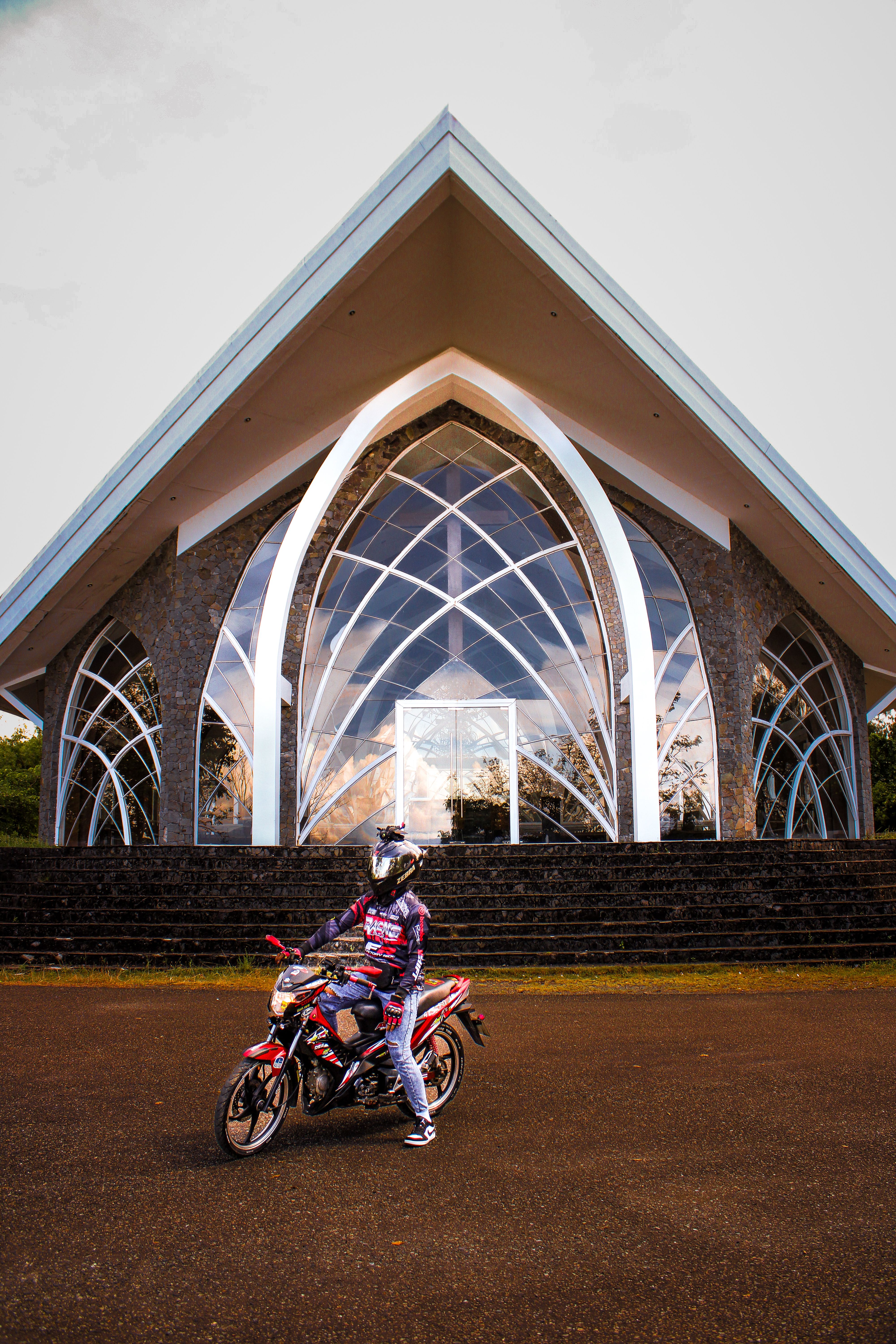 A person on a motorcycle in front of a church · Free Stock Photo