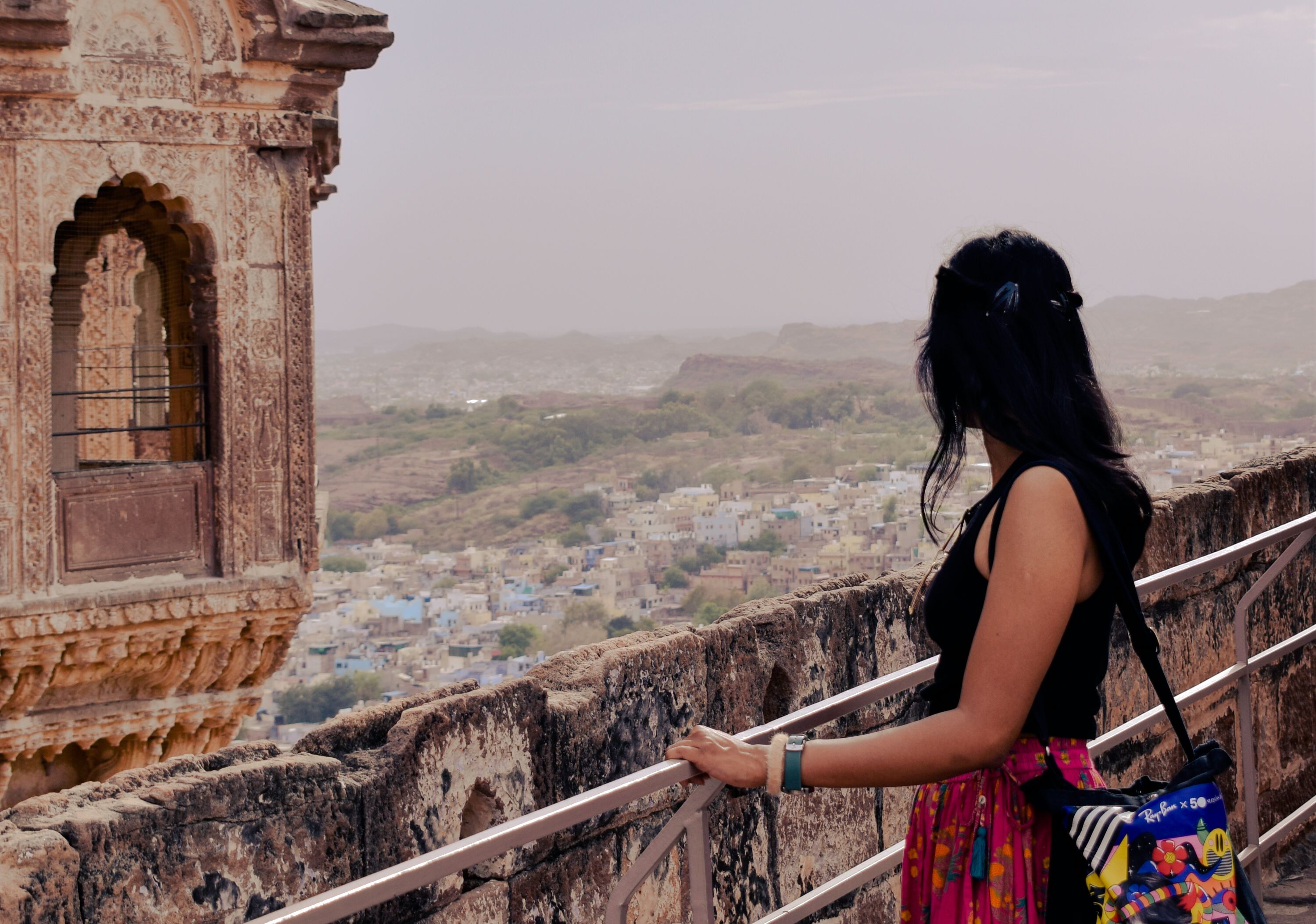 A woman looking out over a city from a balcony · Free Stock Photo
