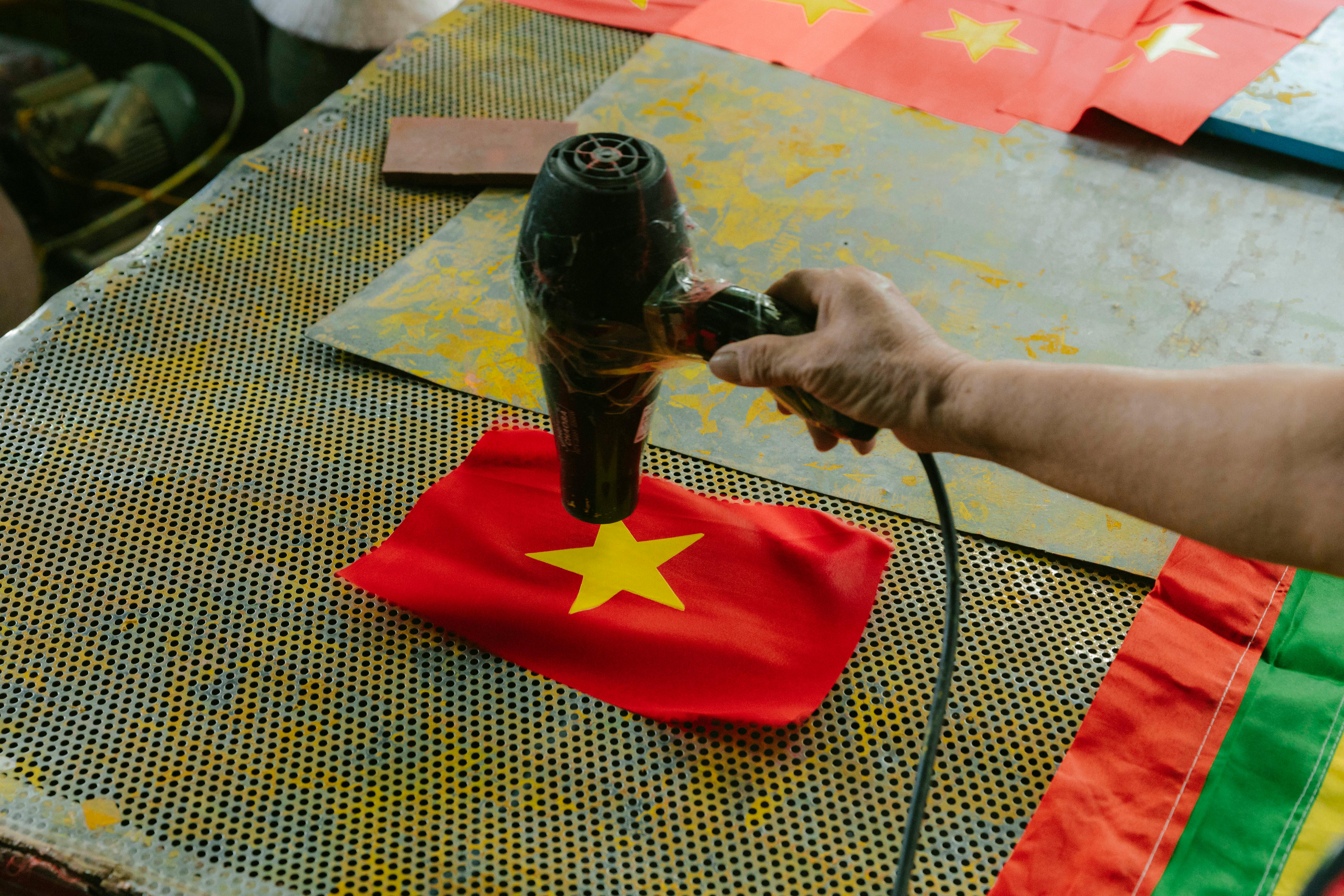 A person using a drill to make a flag · Free Stock Photo
