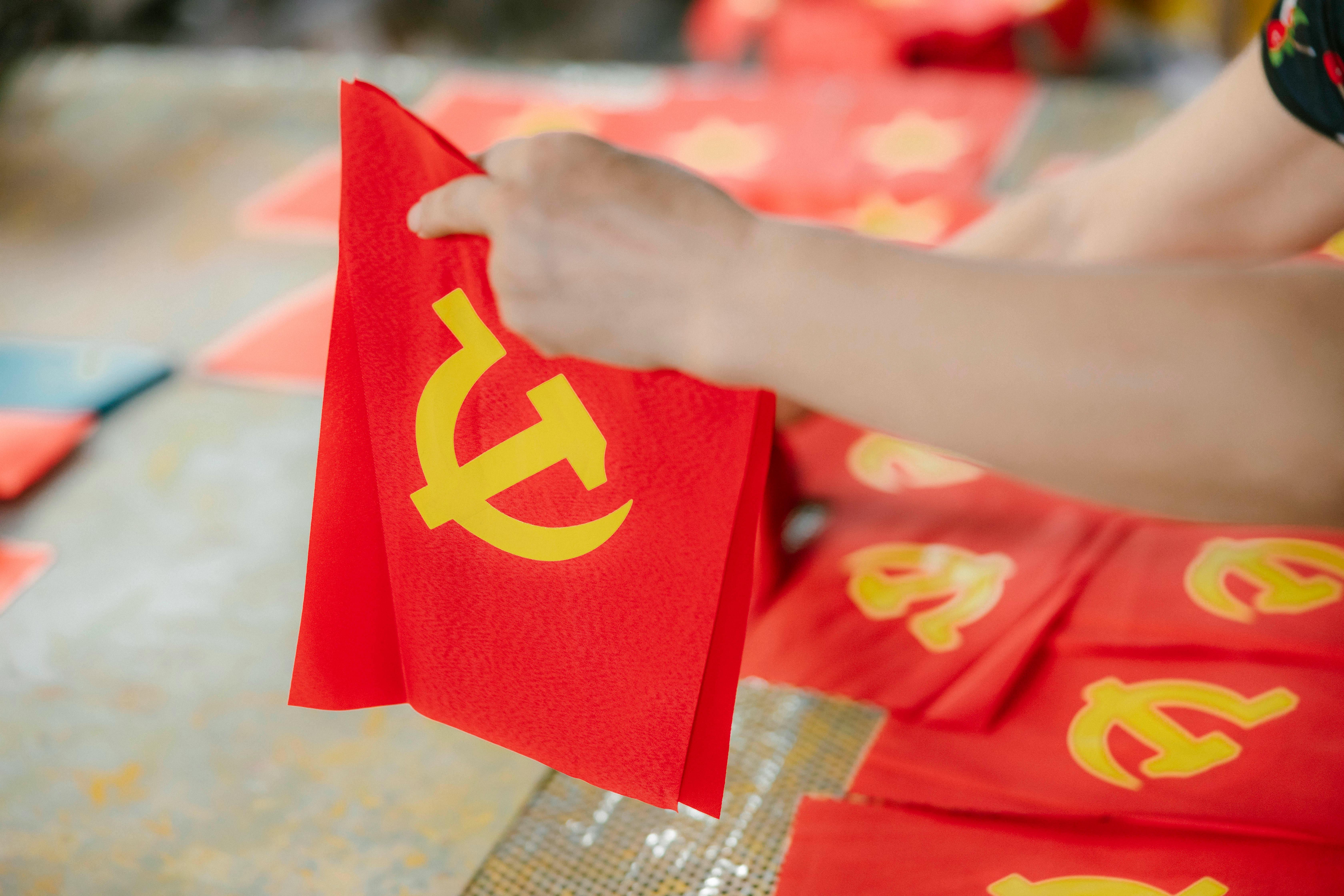 A person is holding a red communist flag · Free Stock Photo