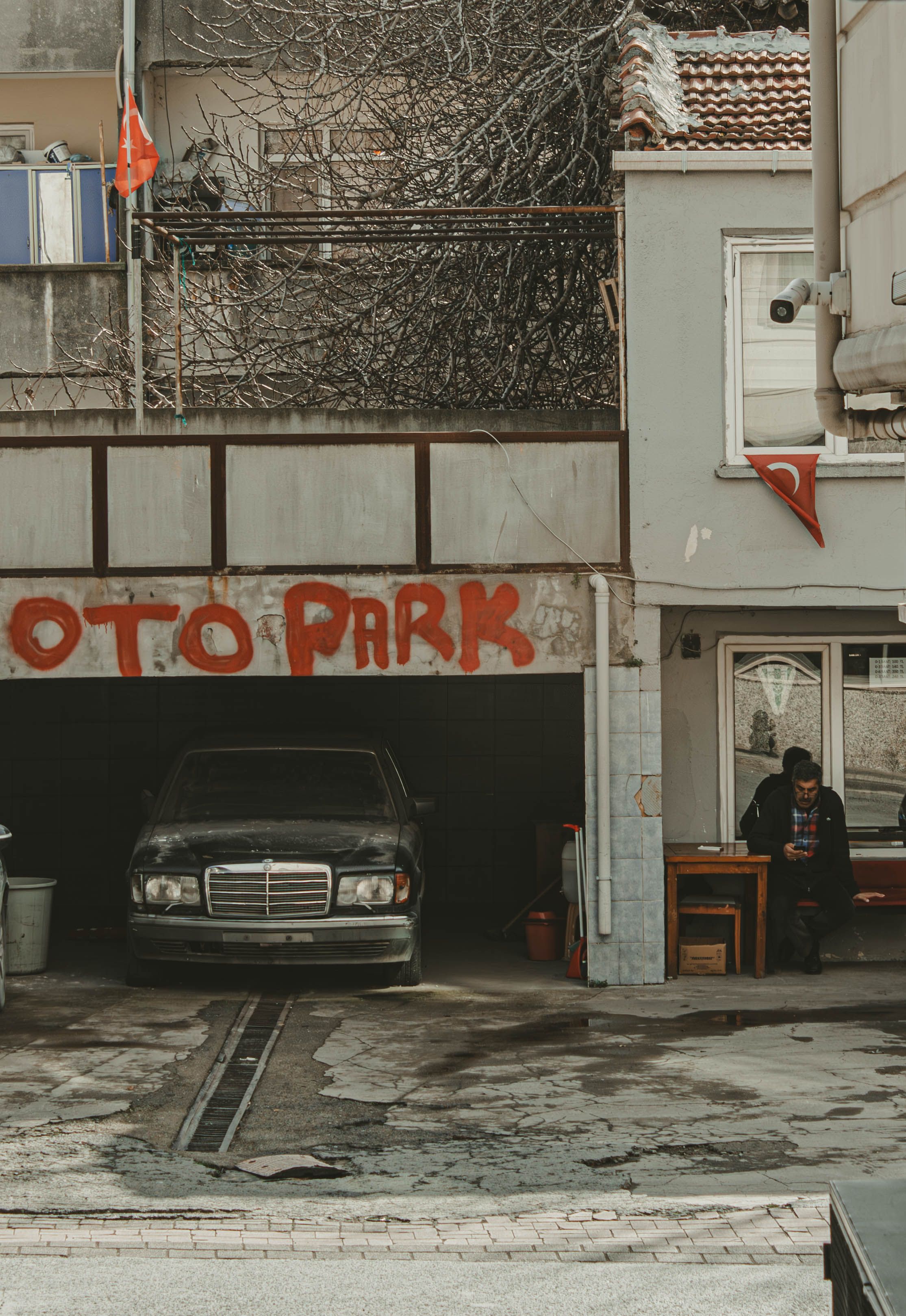 A car parked in front of a garage with graffiti on it · Free Stock Photo