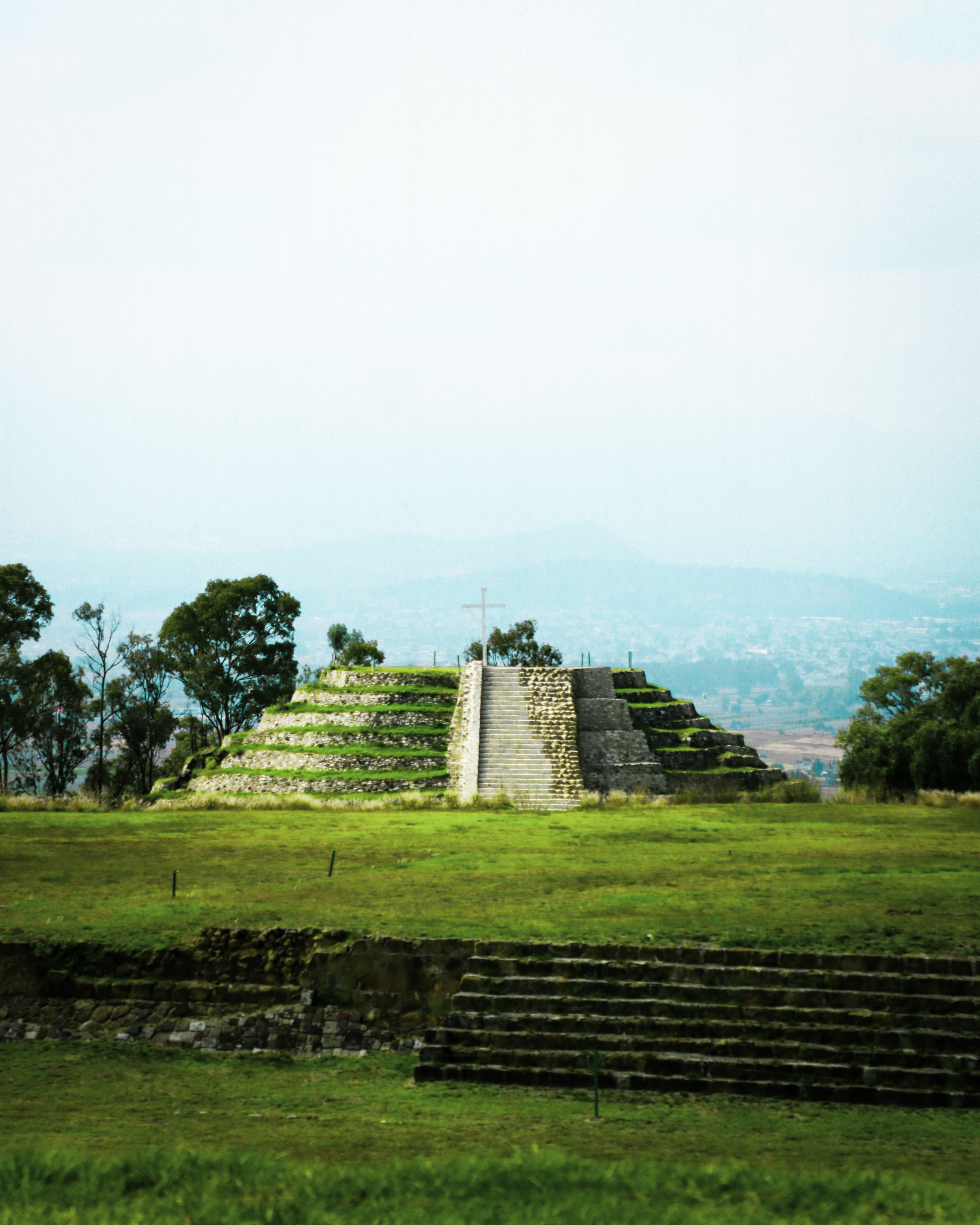 A pyramid with a cross on top in the middle of a field · Free Stock Photo