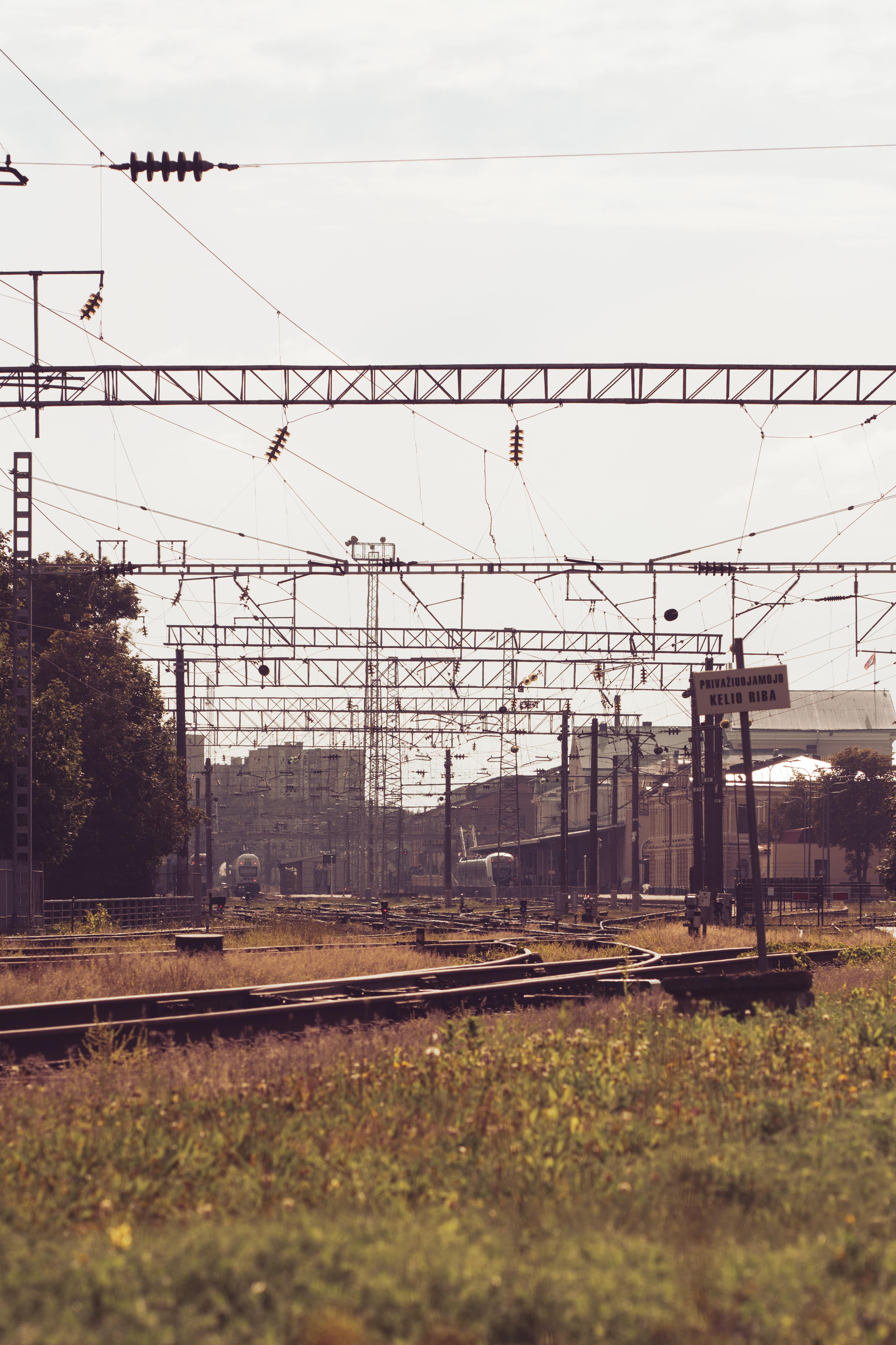 A train track with power lines and a field · Free Stock Photo