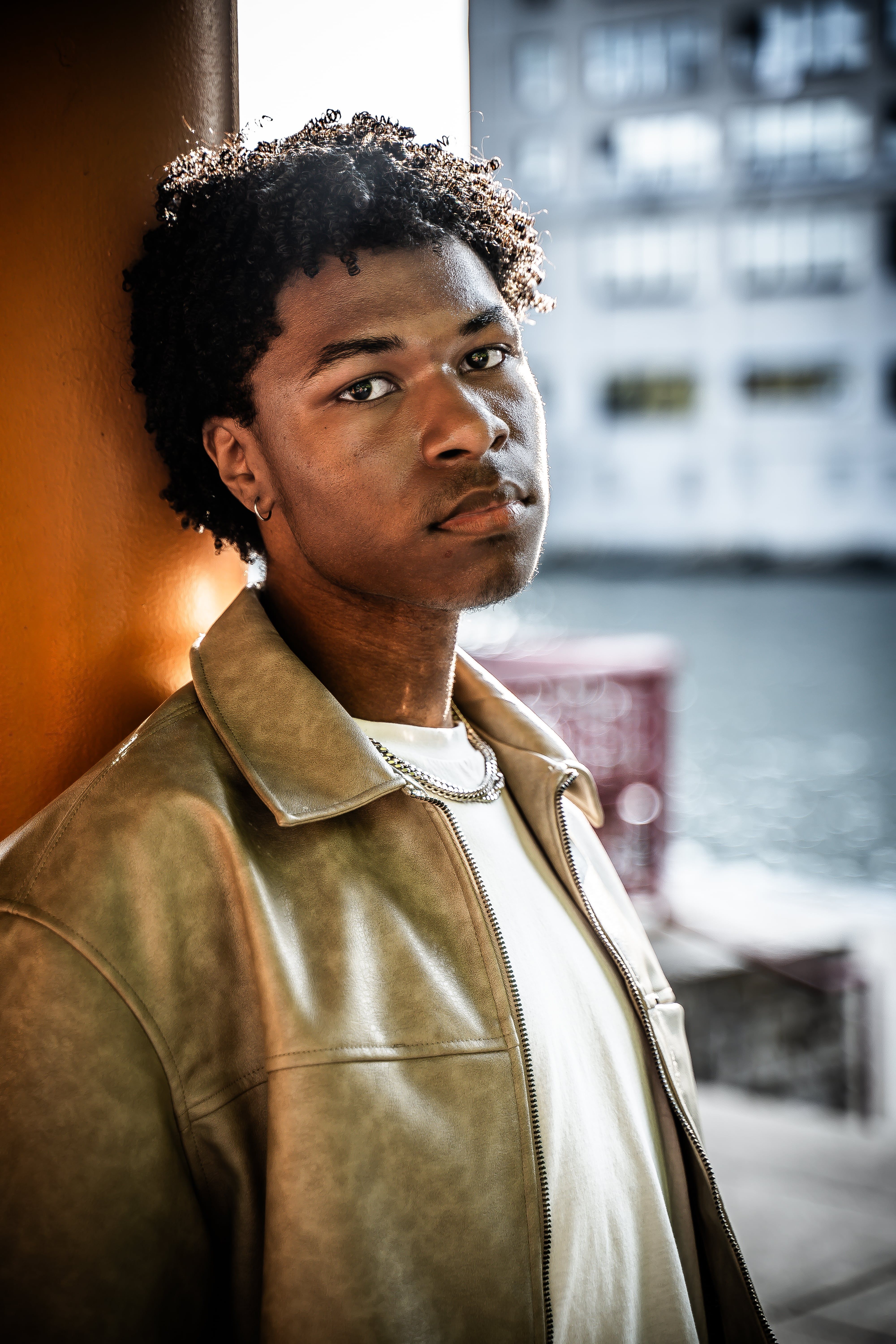 Pensive Young Man by an Urban Riverfront · Free Stock Photo
