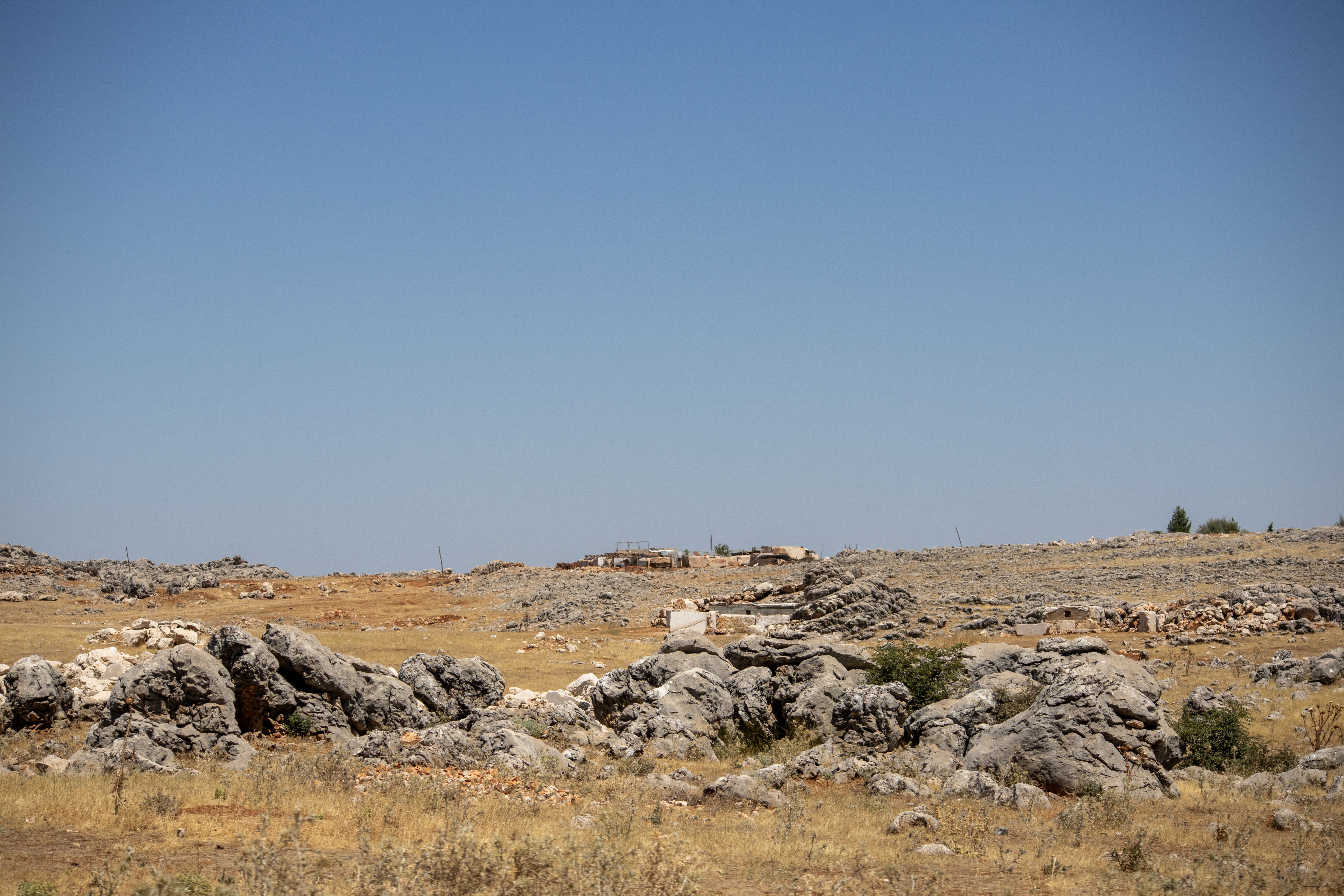 A large rock formation in the middle of a dry field · Free Stock Photo