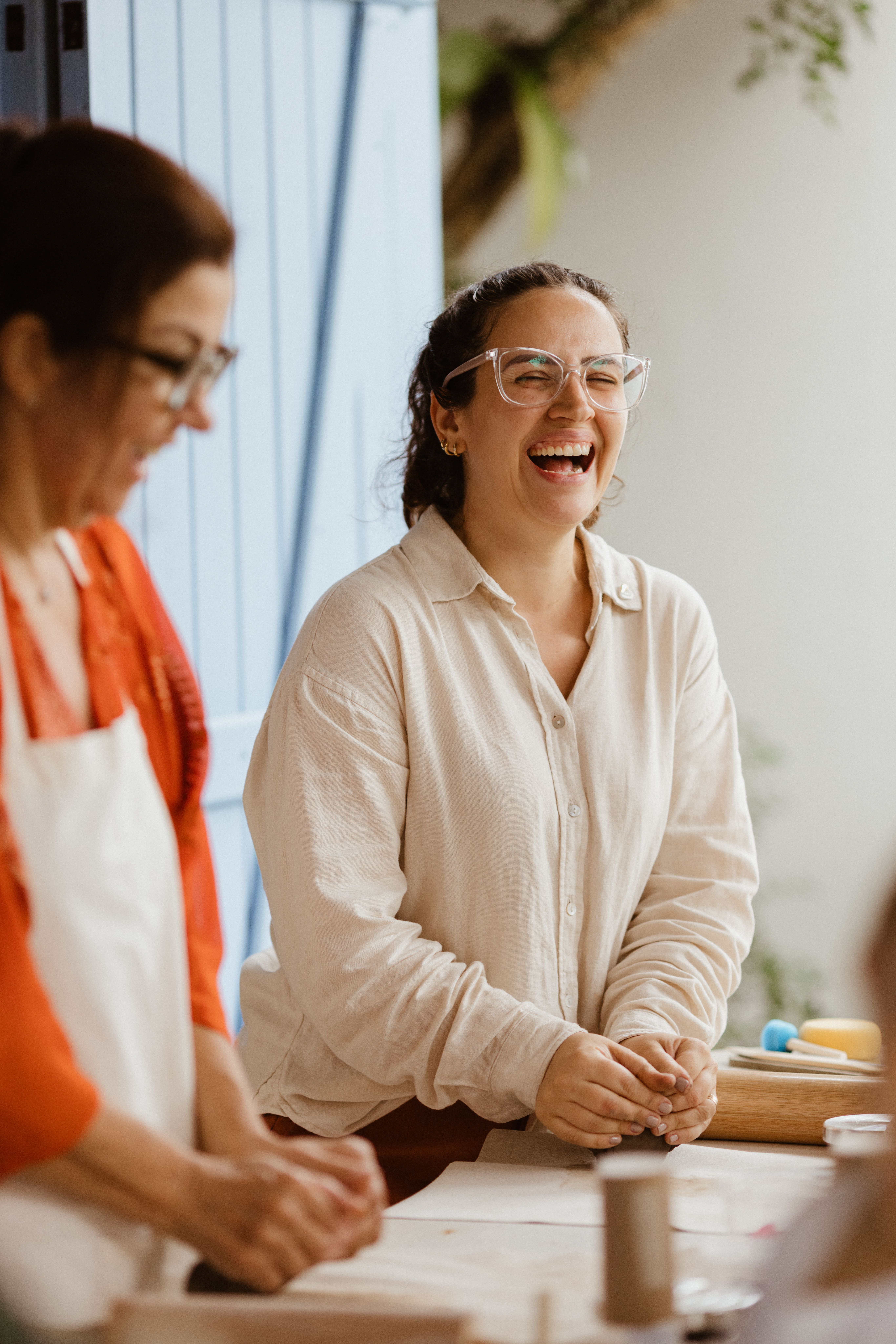 Two women laughing while working on a craft · Free Stock Photo