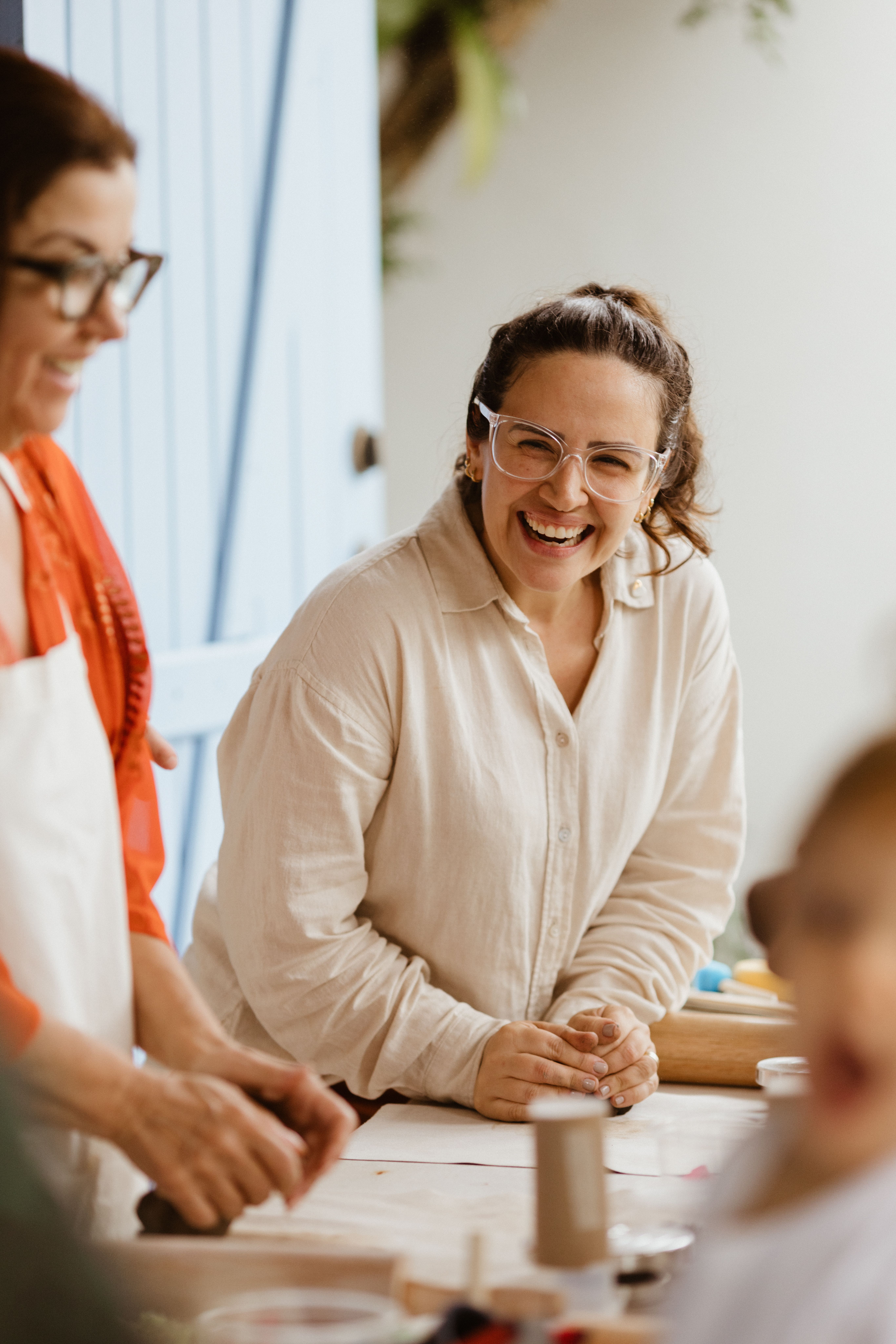 Two women laughing while making crafts together · Free Stock Photo