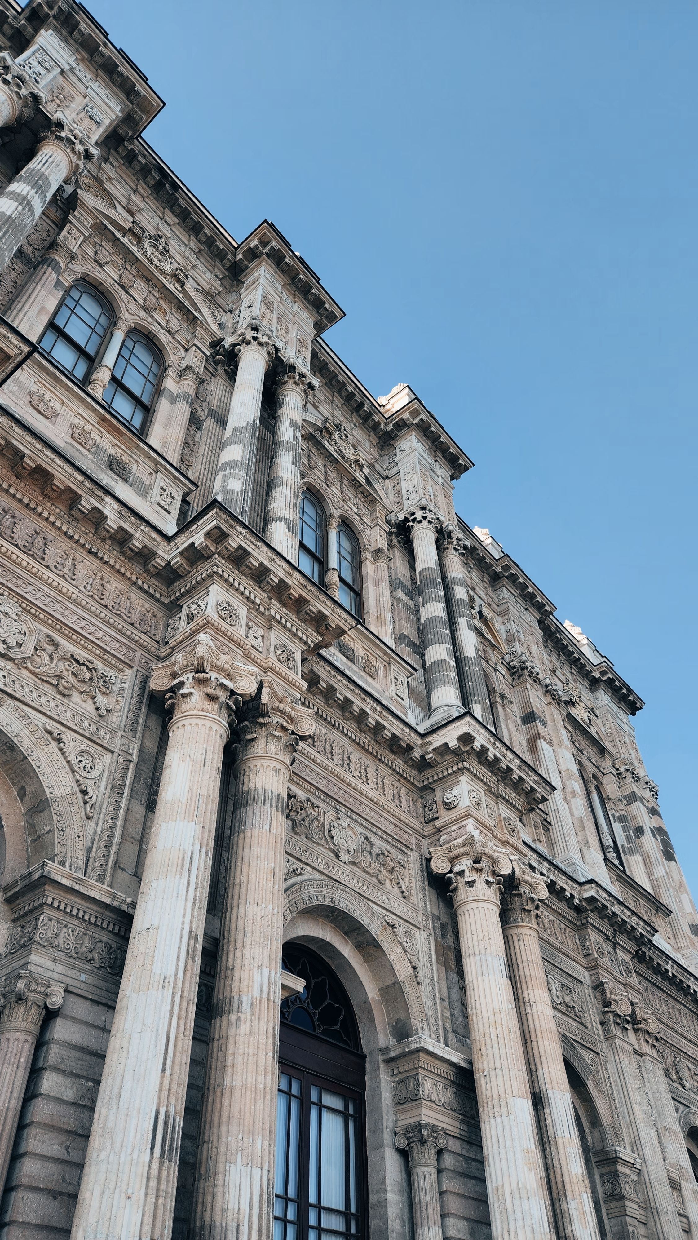 The top of a building with columns and windows · Free Stock Photo