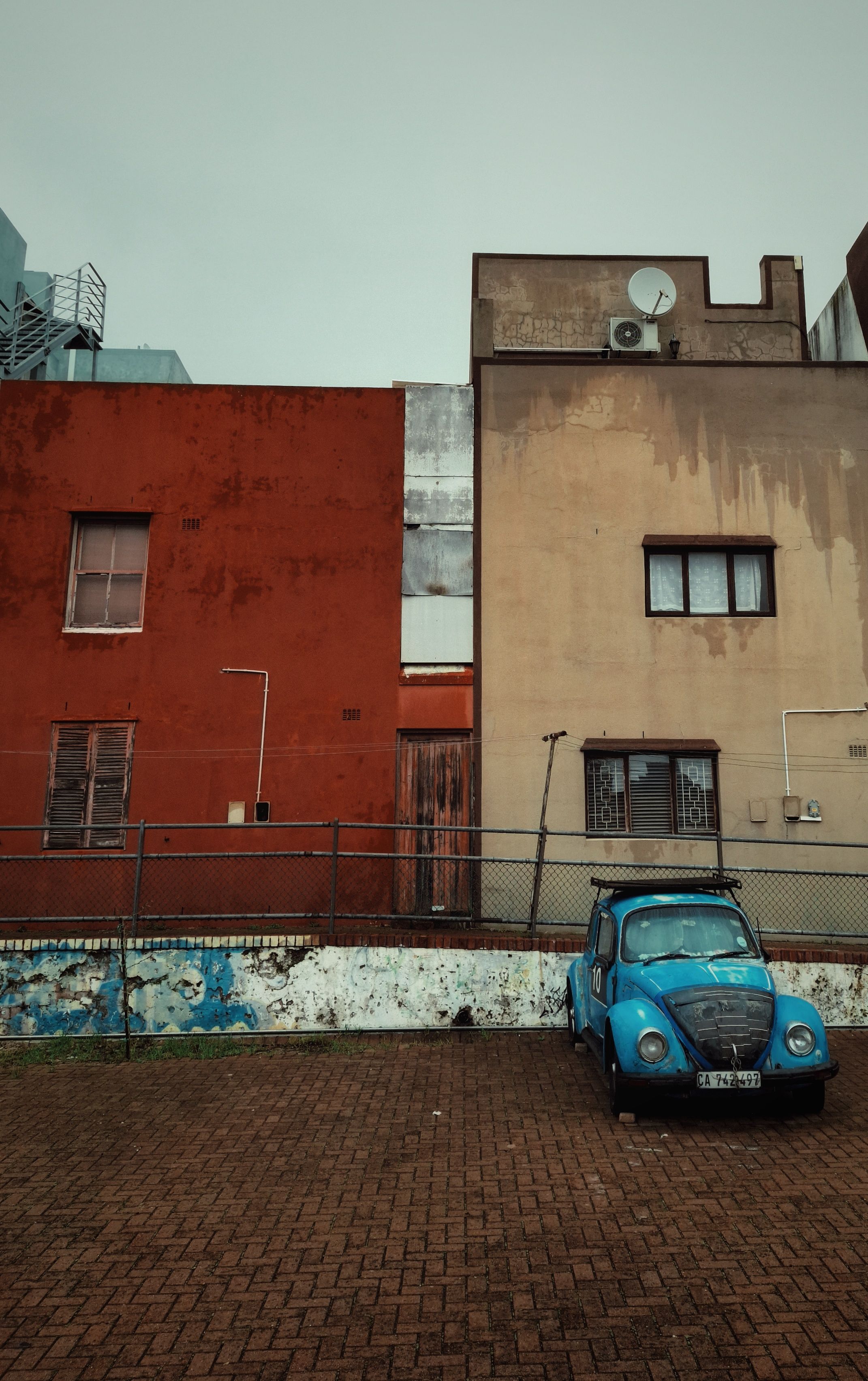A blue car parked in front of a building · Free Stock Photo