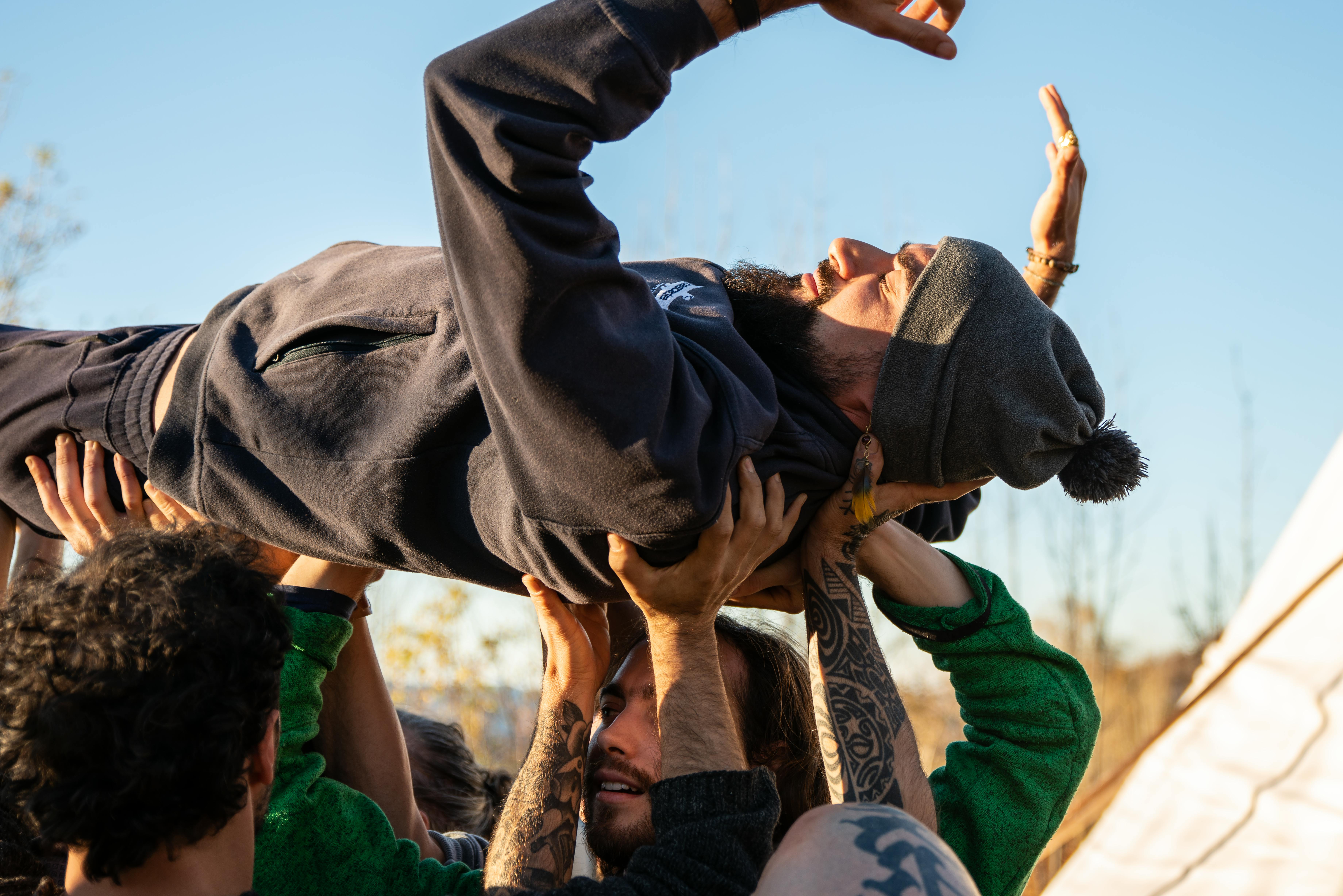 A man is being lifted up by his friends · Free Stock Photo