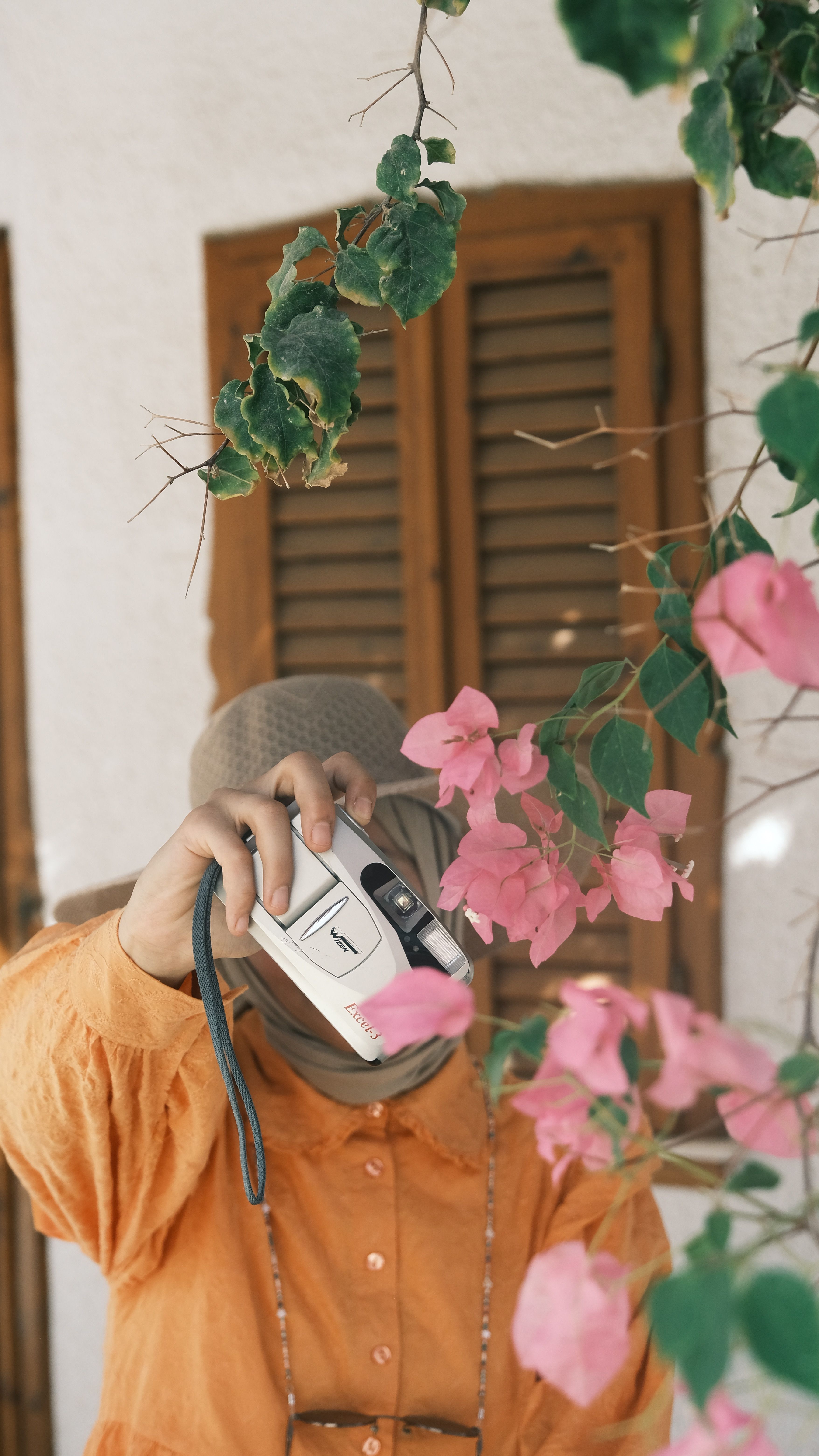A person taking a photo of flowers with a camera · Free Stock Photo