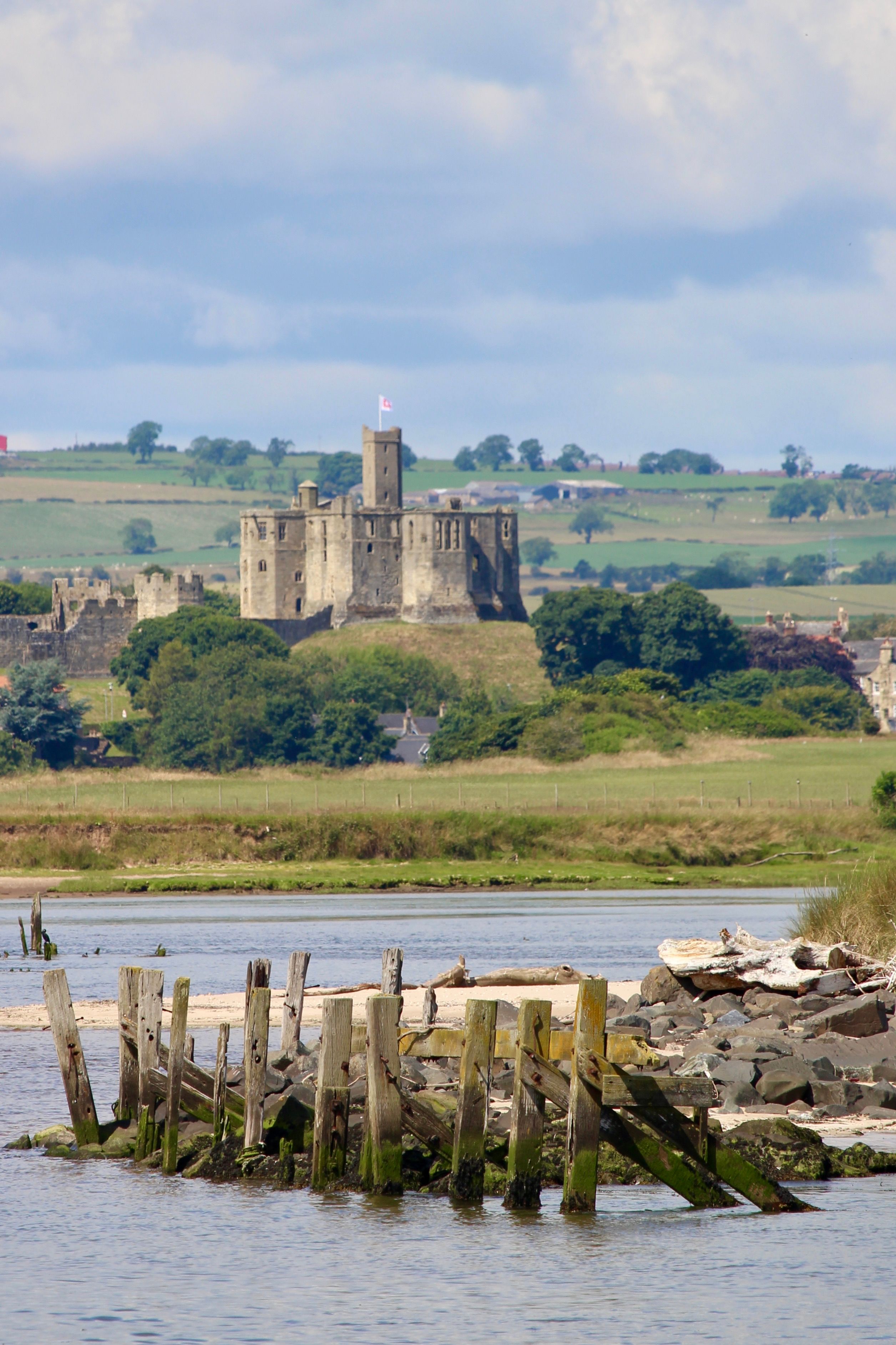 A castle sits on a hill overlooking the water · Free Stock Photo