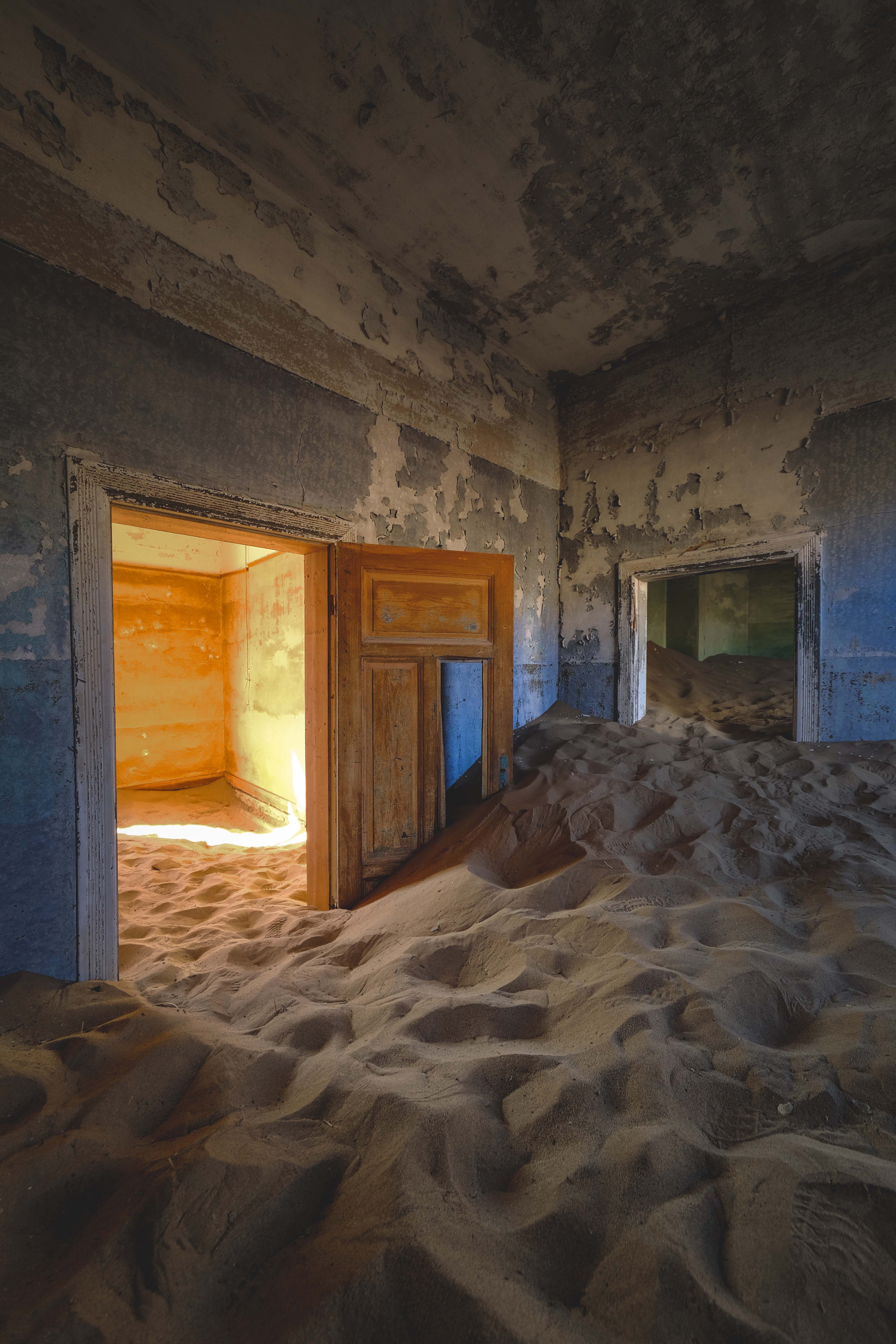 An empty room with sand in it and doors · Free Stock Photo