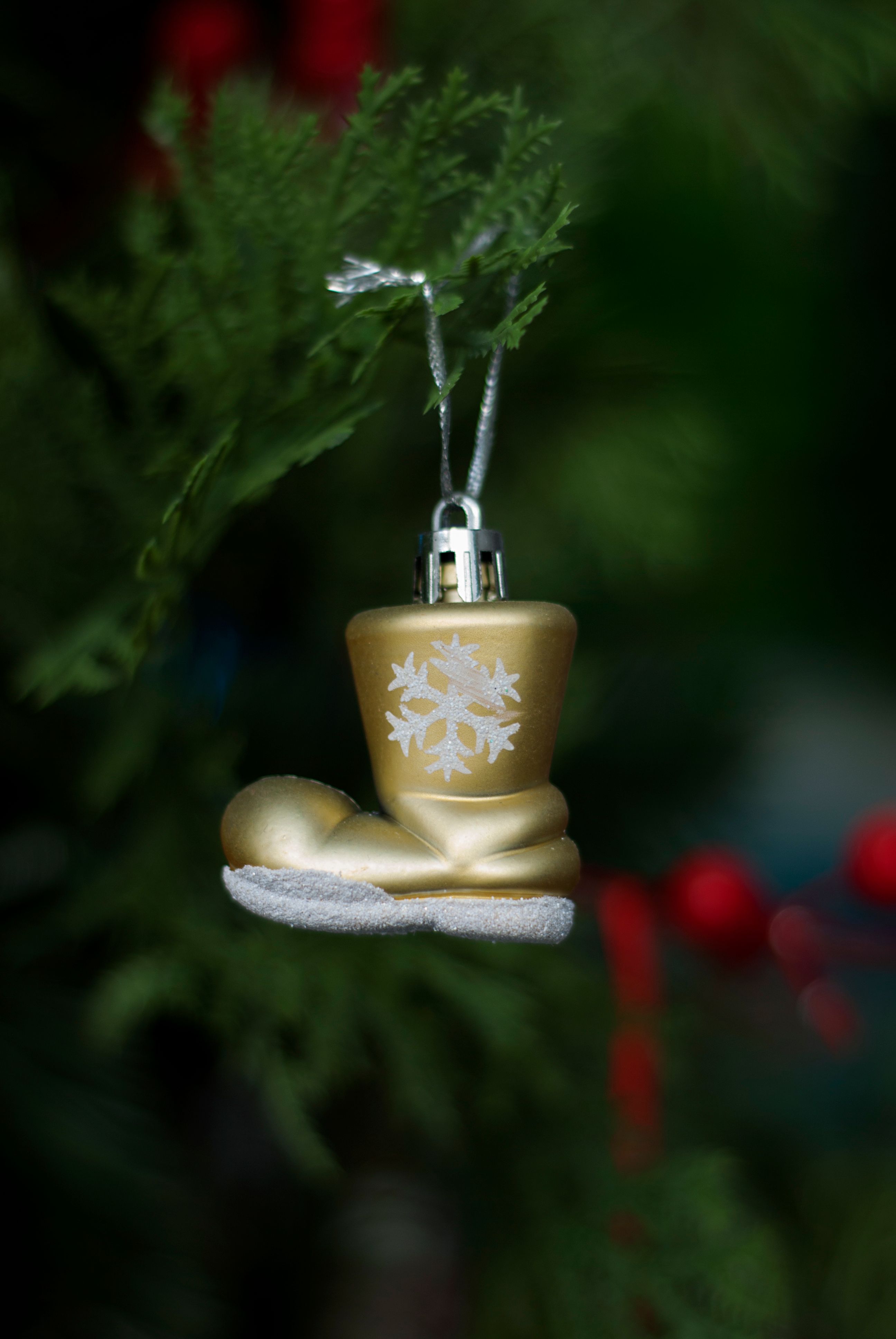 A gold boot ornament hanging from a christmas tree · Free Stock Photo