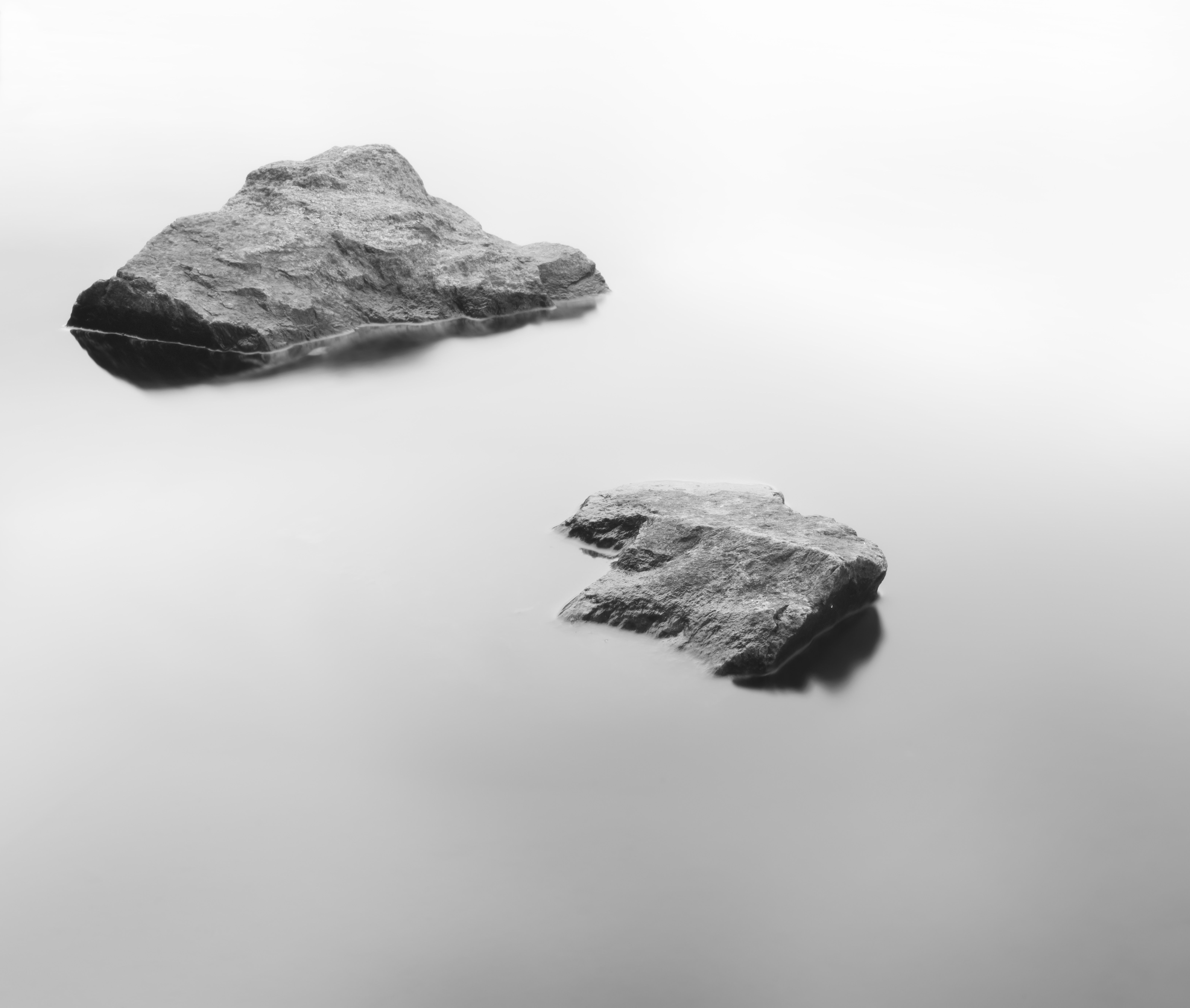 Two rocks in the water in black and white · Free Stock Photo