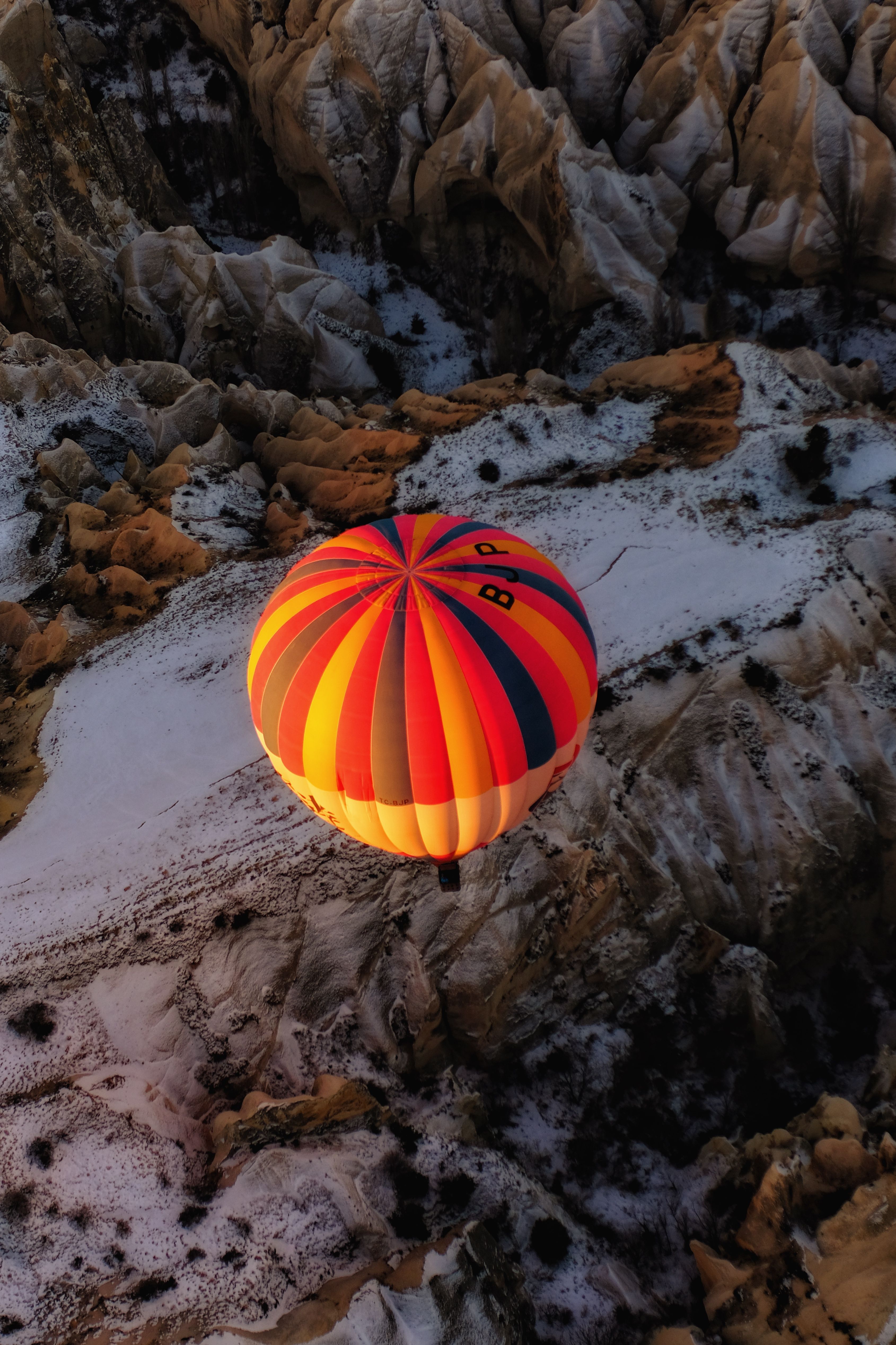 A hot air balloon flying over a rocky landscape · Free Stock Photo