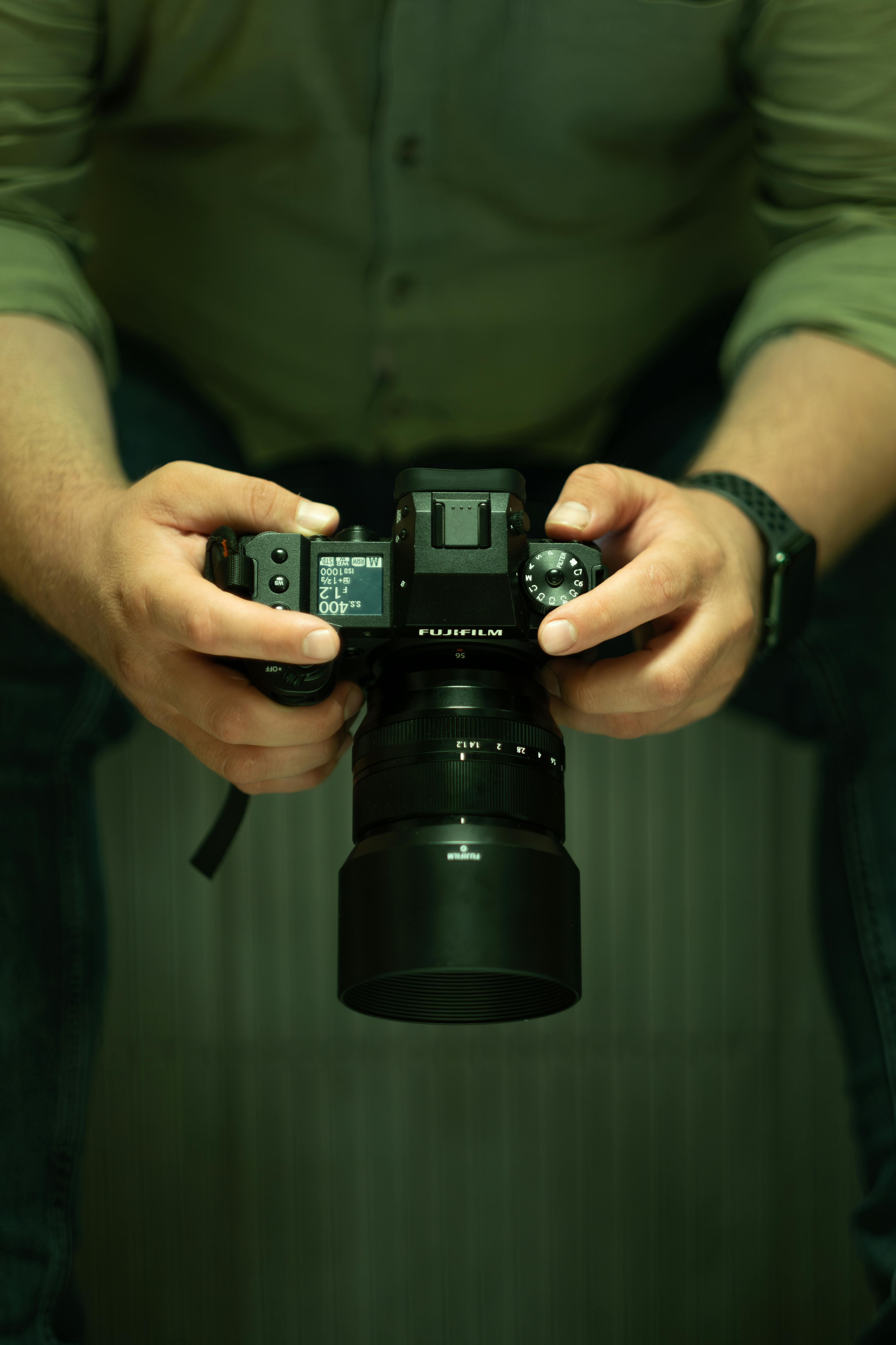 A man holding a camera with his hands · Free Stock Photo