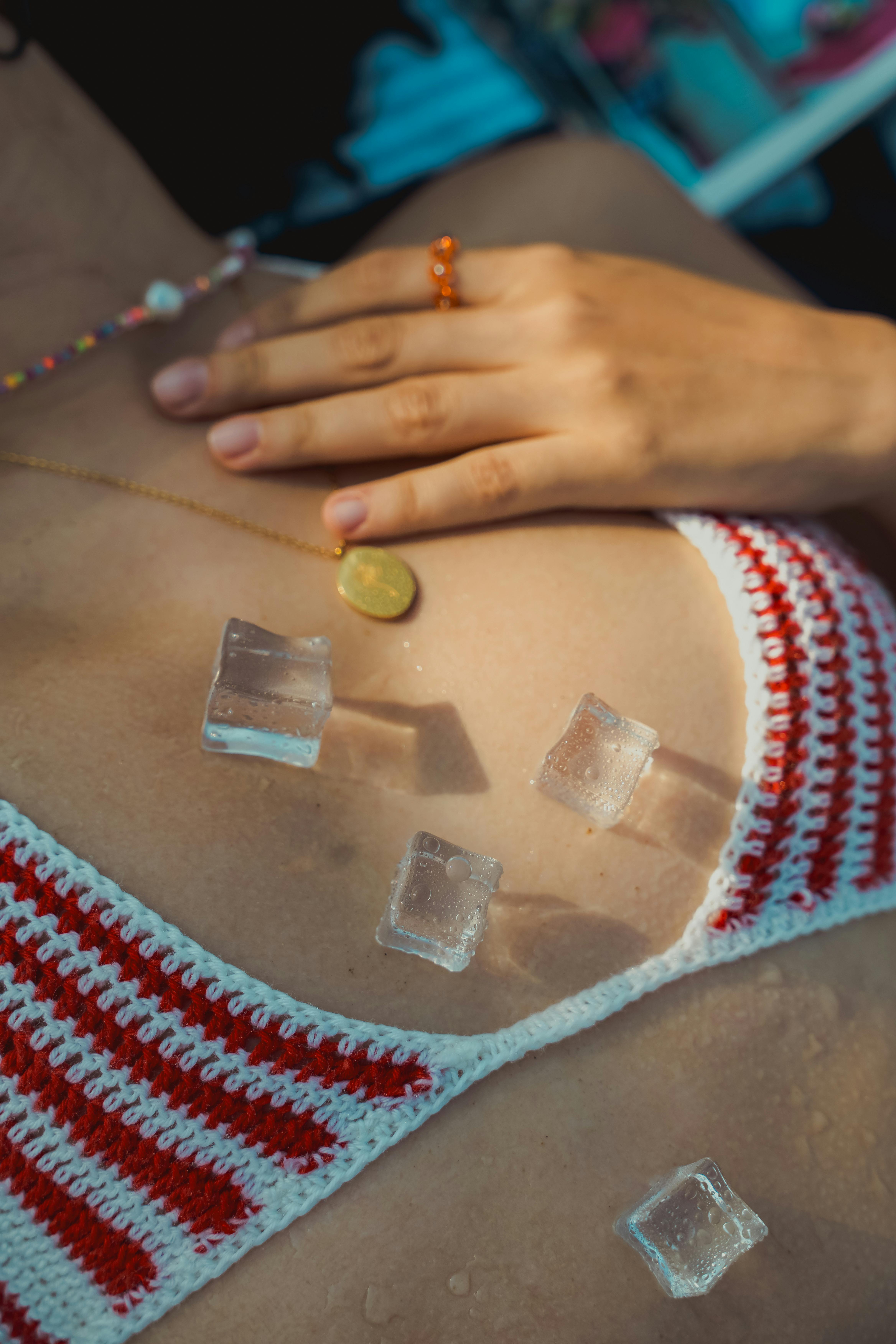 A woman in a bikini top with ice cubes on her chest · Free Stock Photo