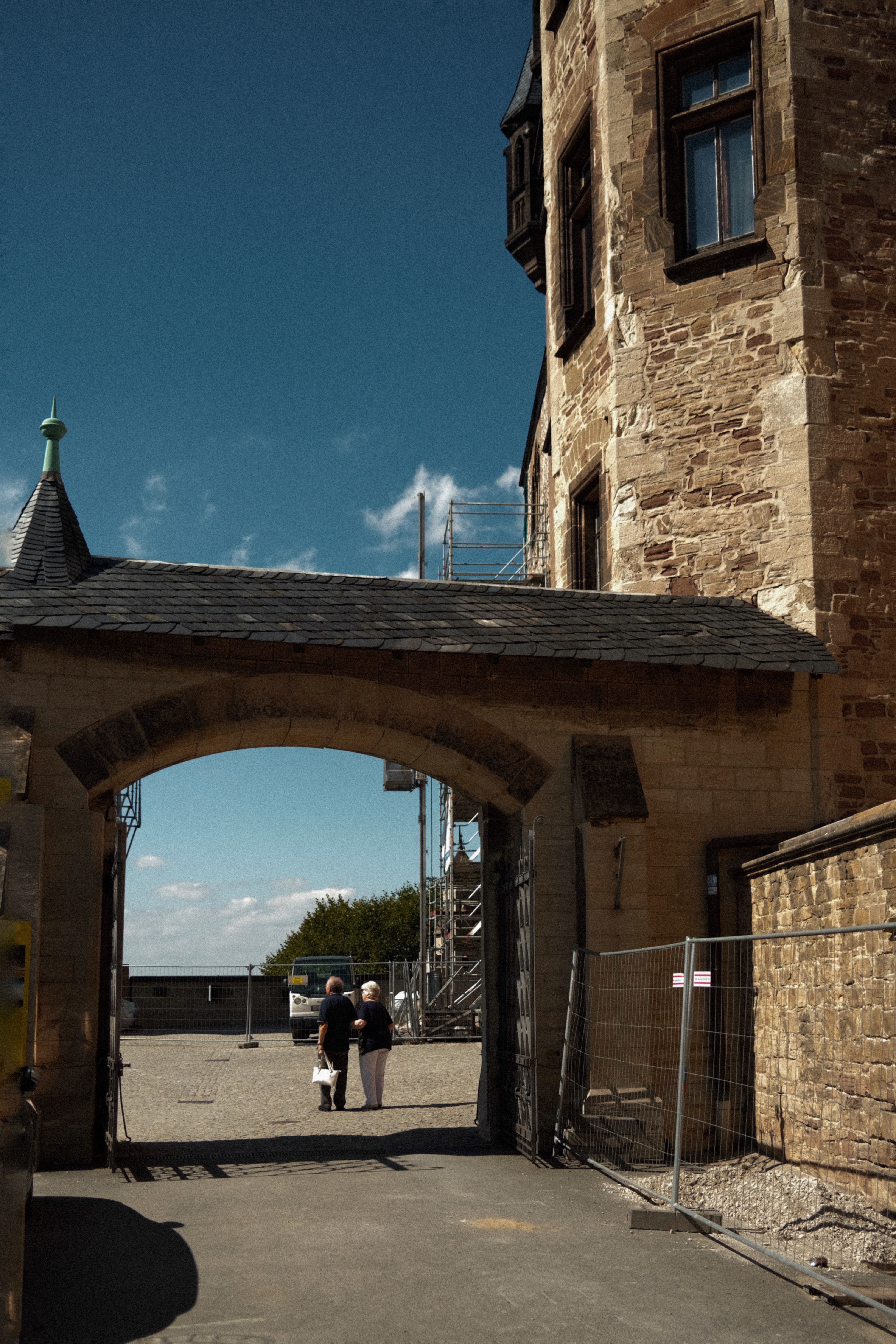 A man walking through an archway in front of a castle · Free Stock Photo