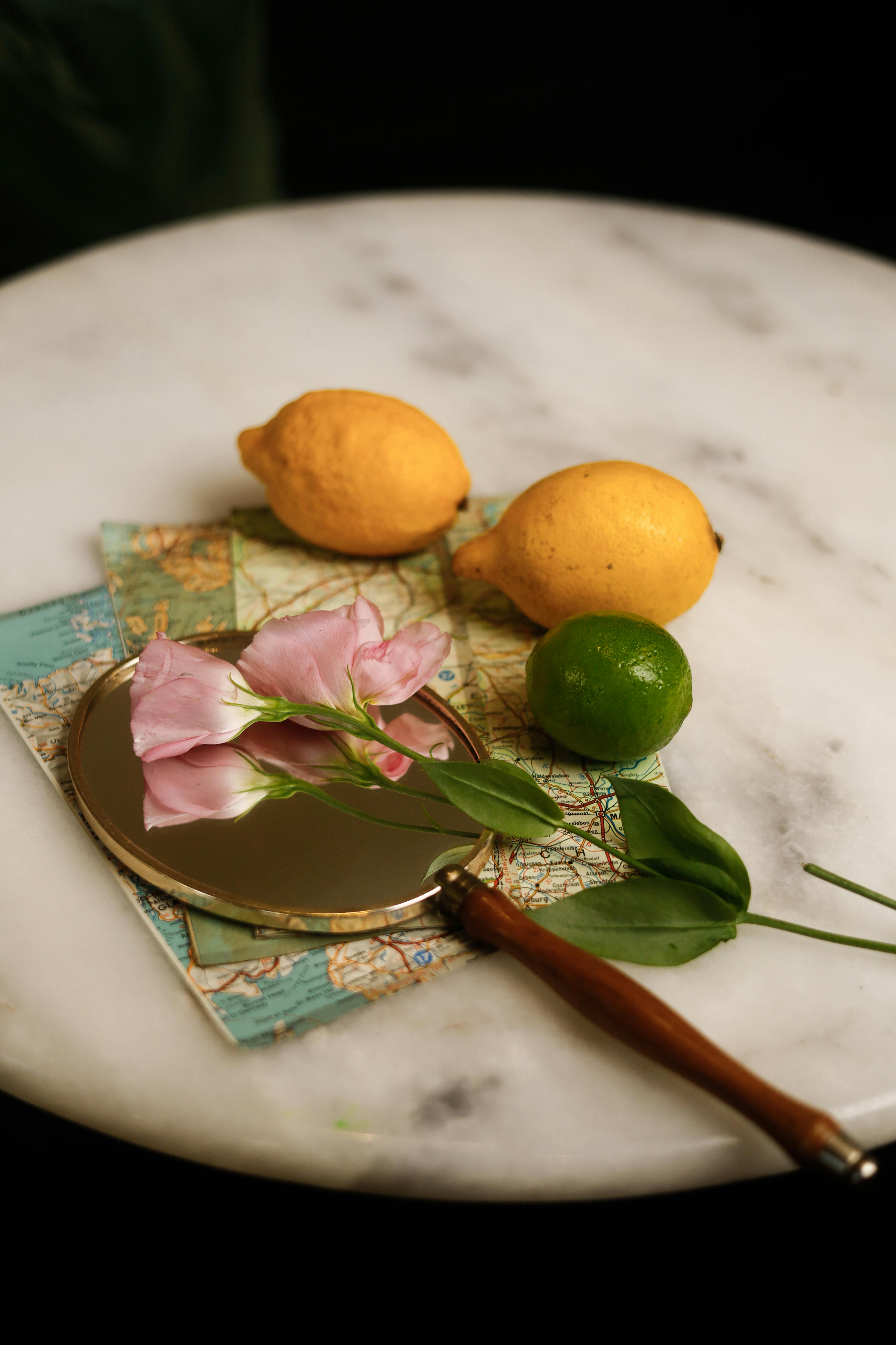 A table with a mirror, lemon and rose · Free Stock Photo