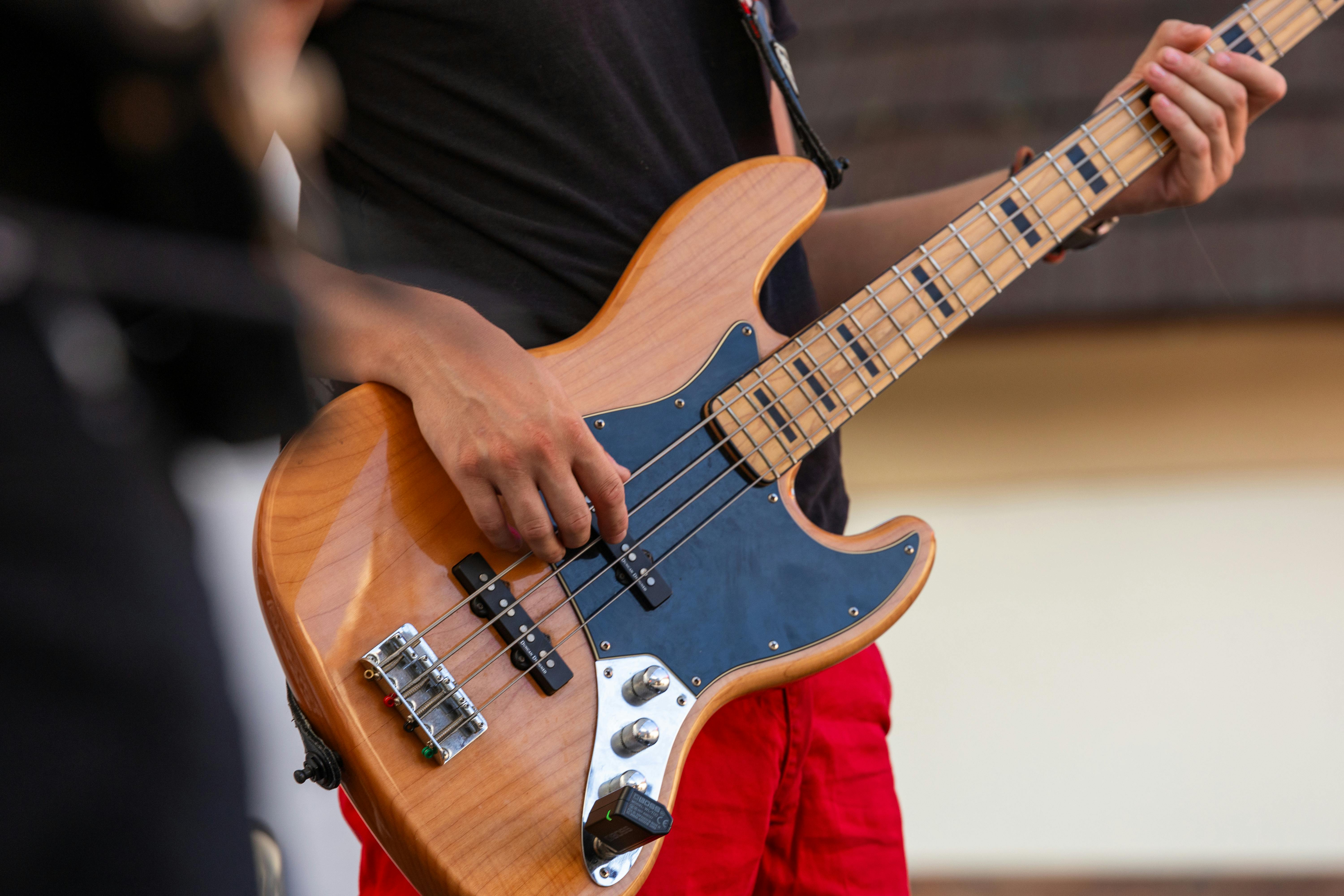 A person playing a bass guitar in a crowd · Free Stock Photo