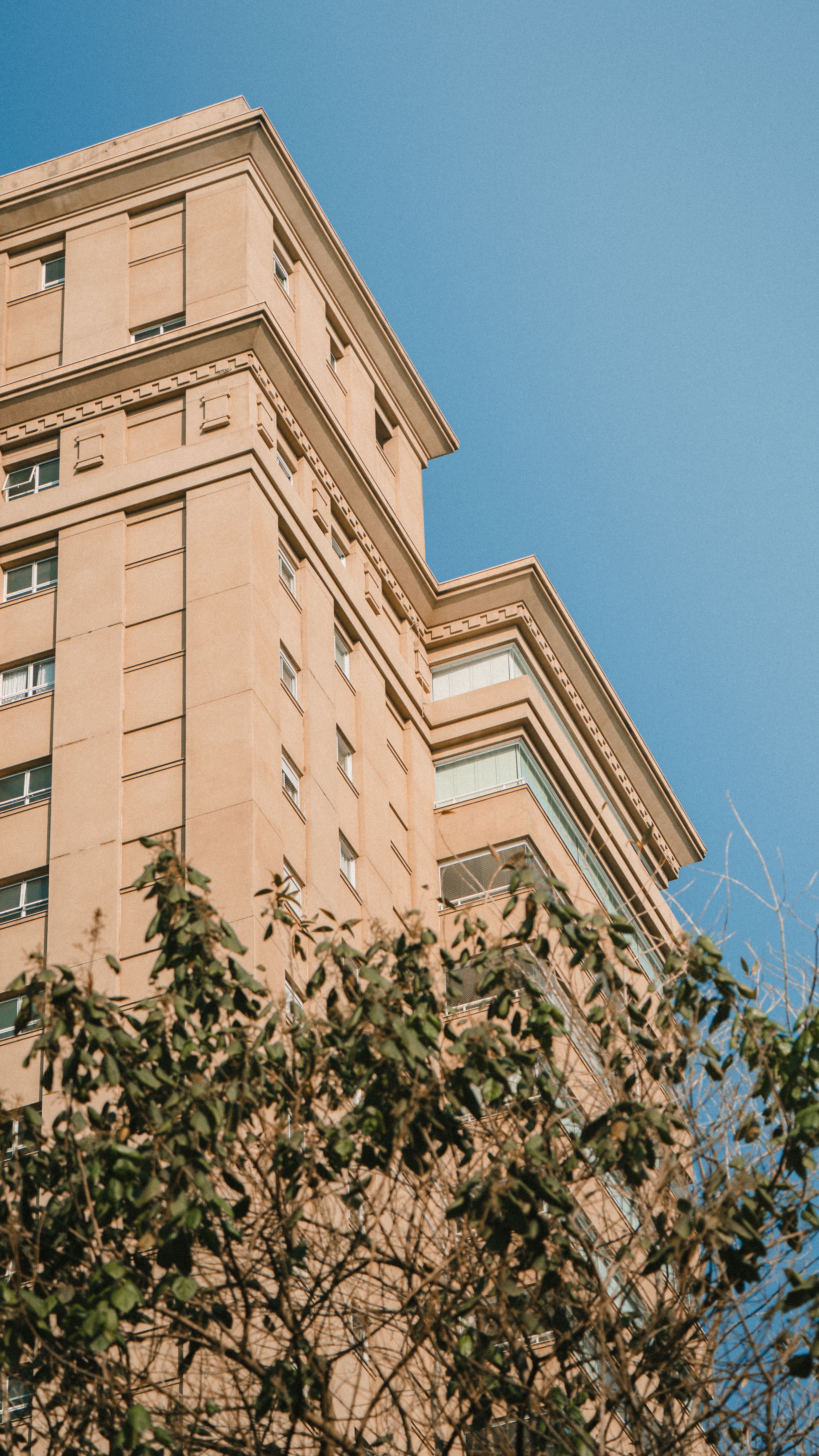 A tall building with a blue sky above it · Free Stock Photo