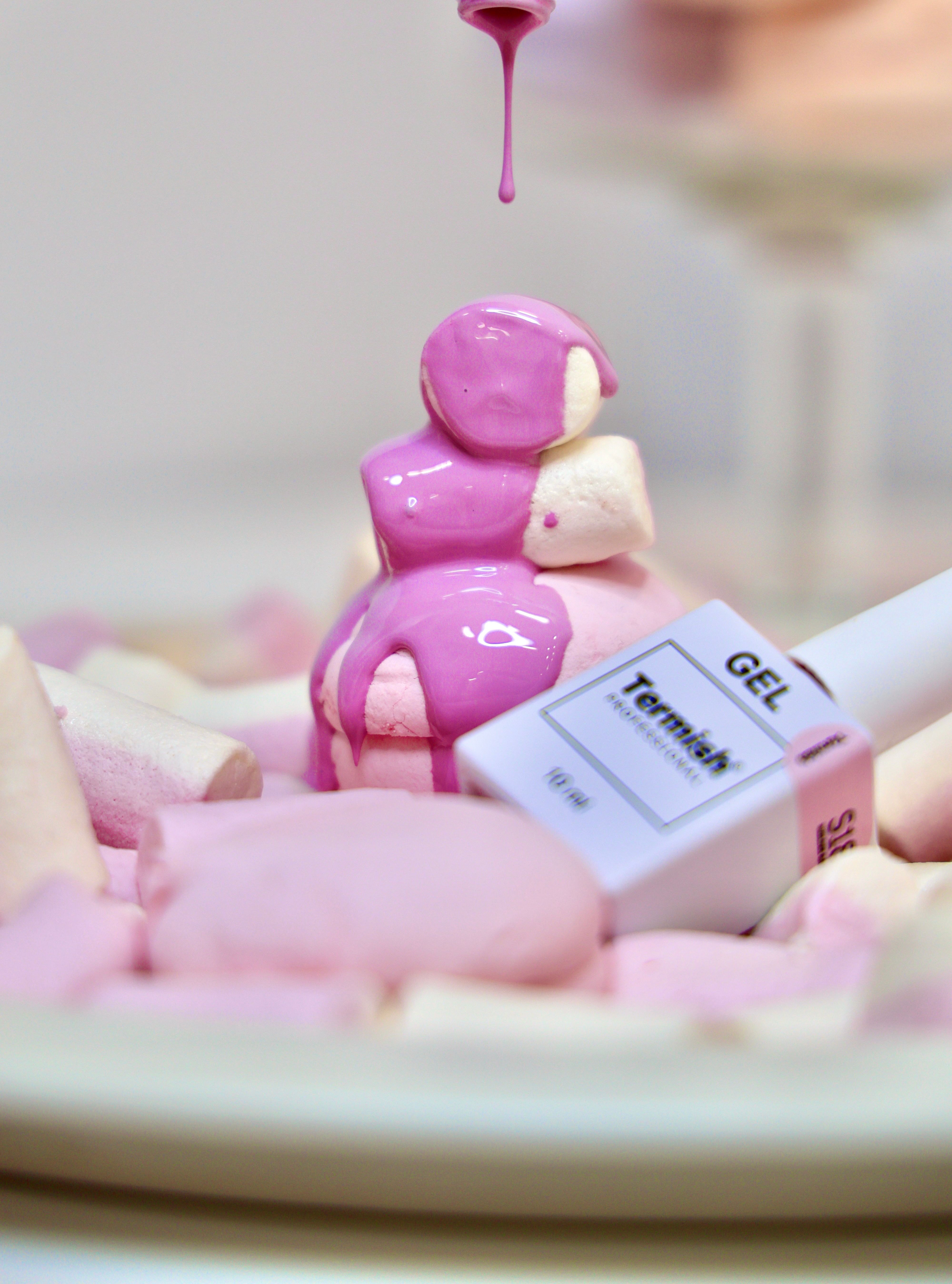 A pink liquid being poured onto marshmallows · Free Stock Photo