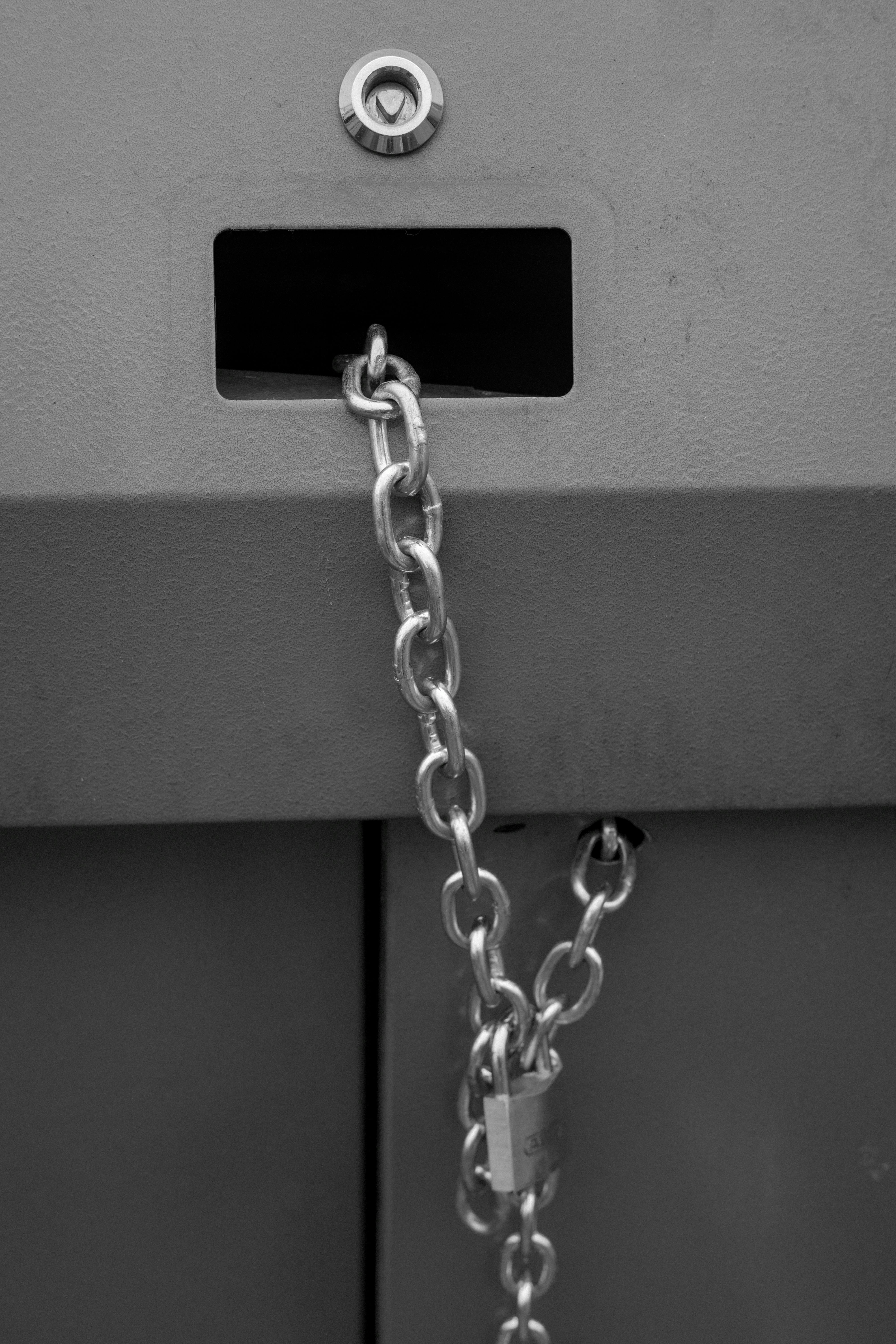 A black and white photo of a metal box with chains · Free Stock Photo
