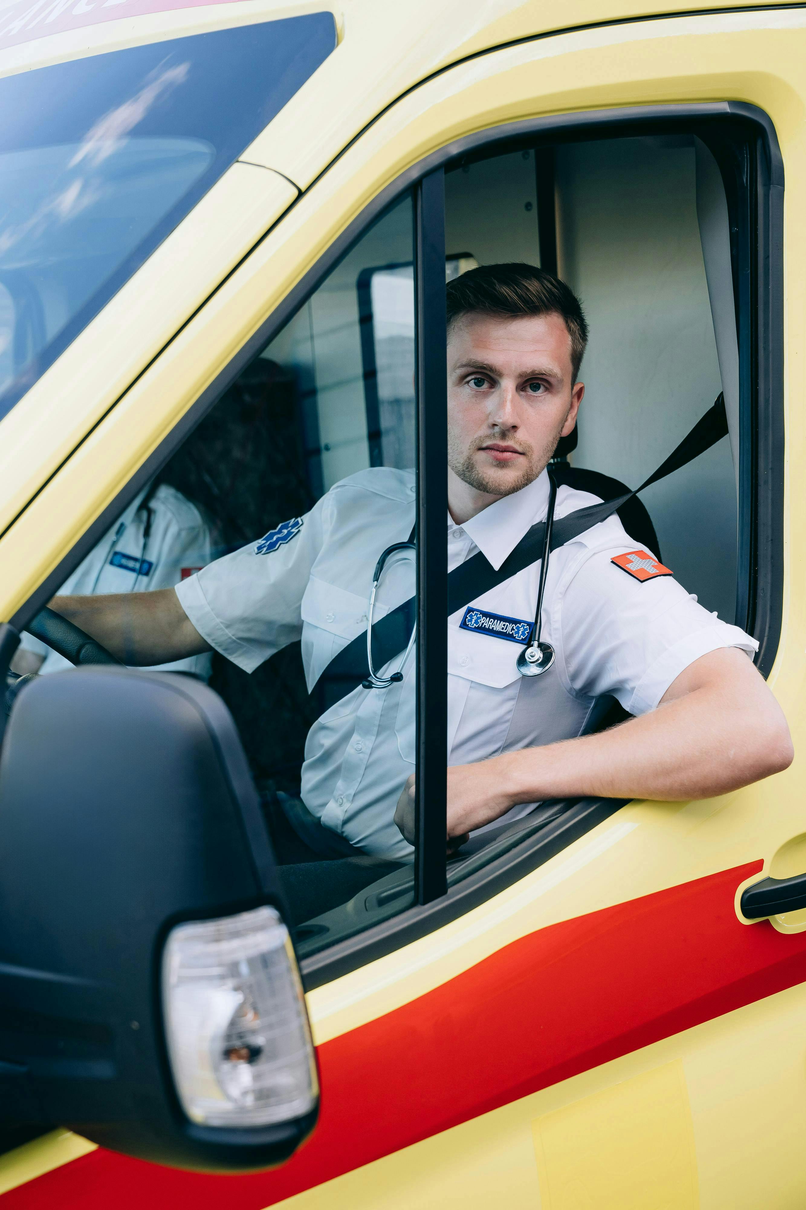 Paramédico Sentado No Volante Da Ambulância · Foto profissional gratuita