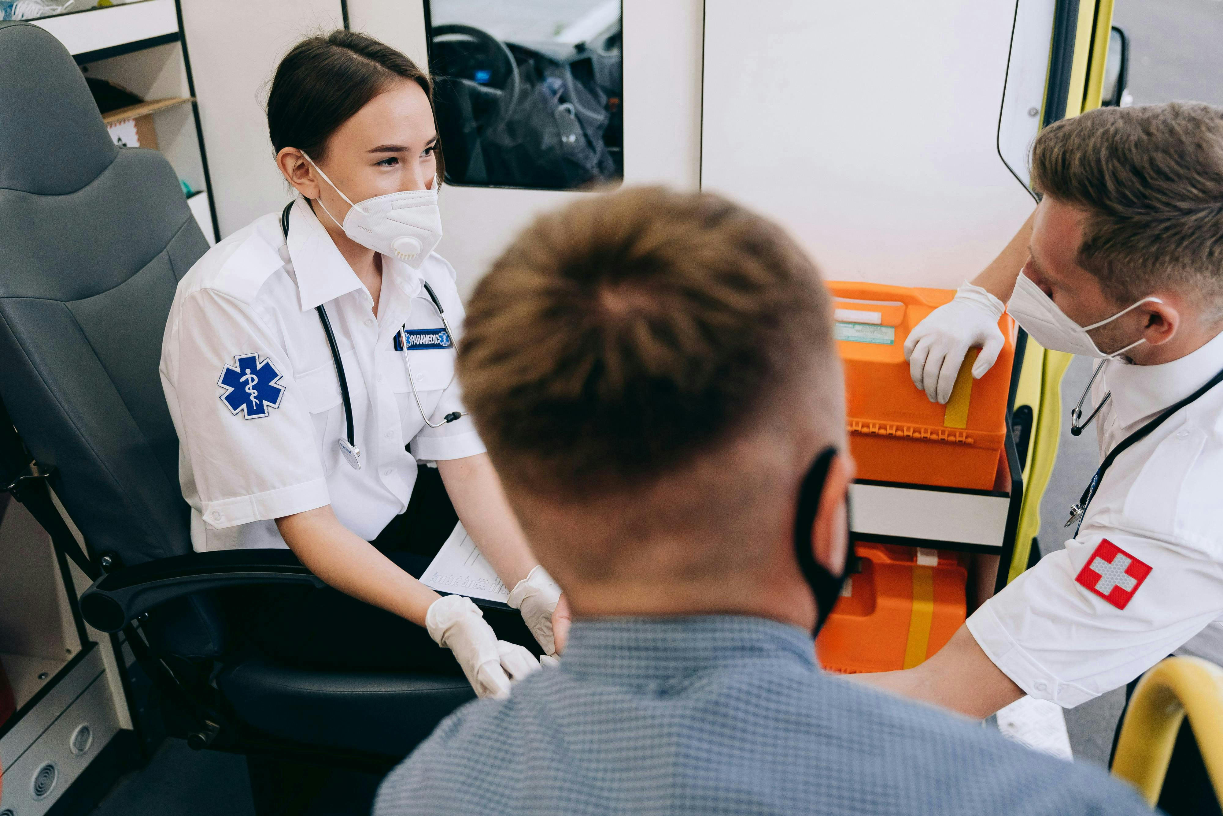 Paramedics Examining Casualty in Ambulance · Free Stock Photo