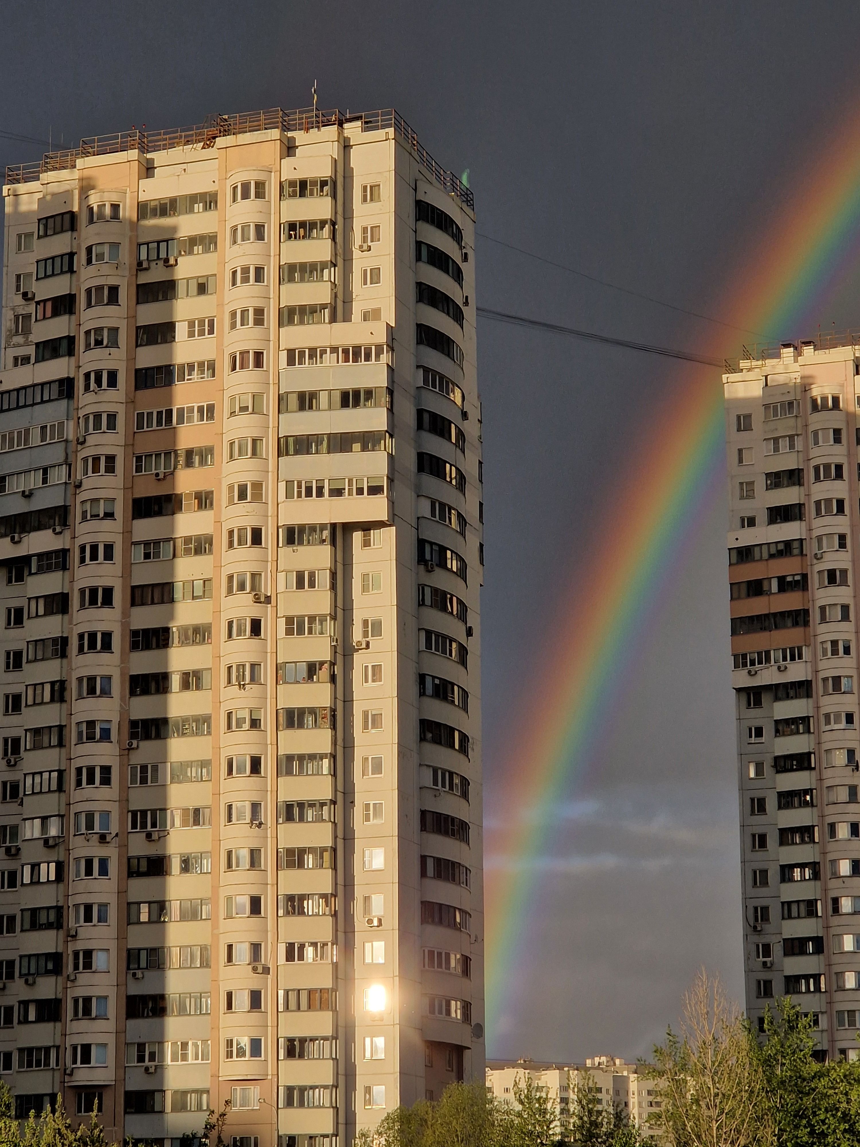 A rainbow is seen over two high rise buildings · Free Stock Photo