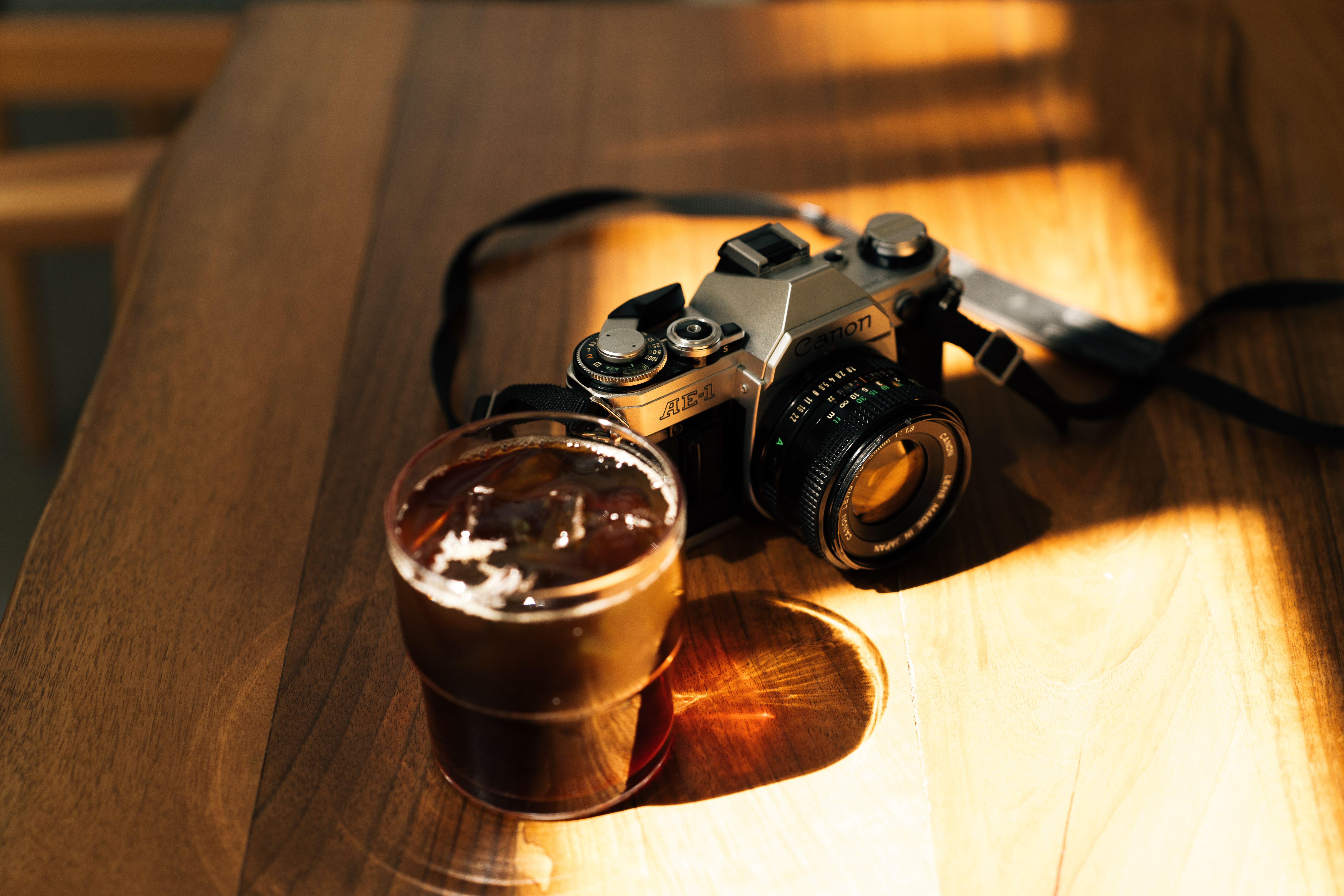A camera and a glass of beer on a table · Free Stock Photo
