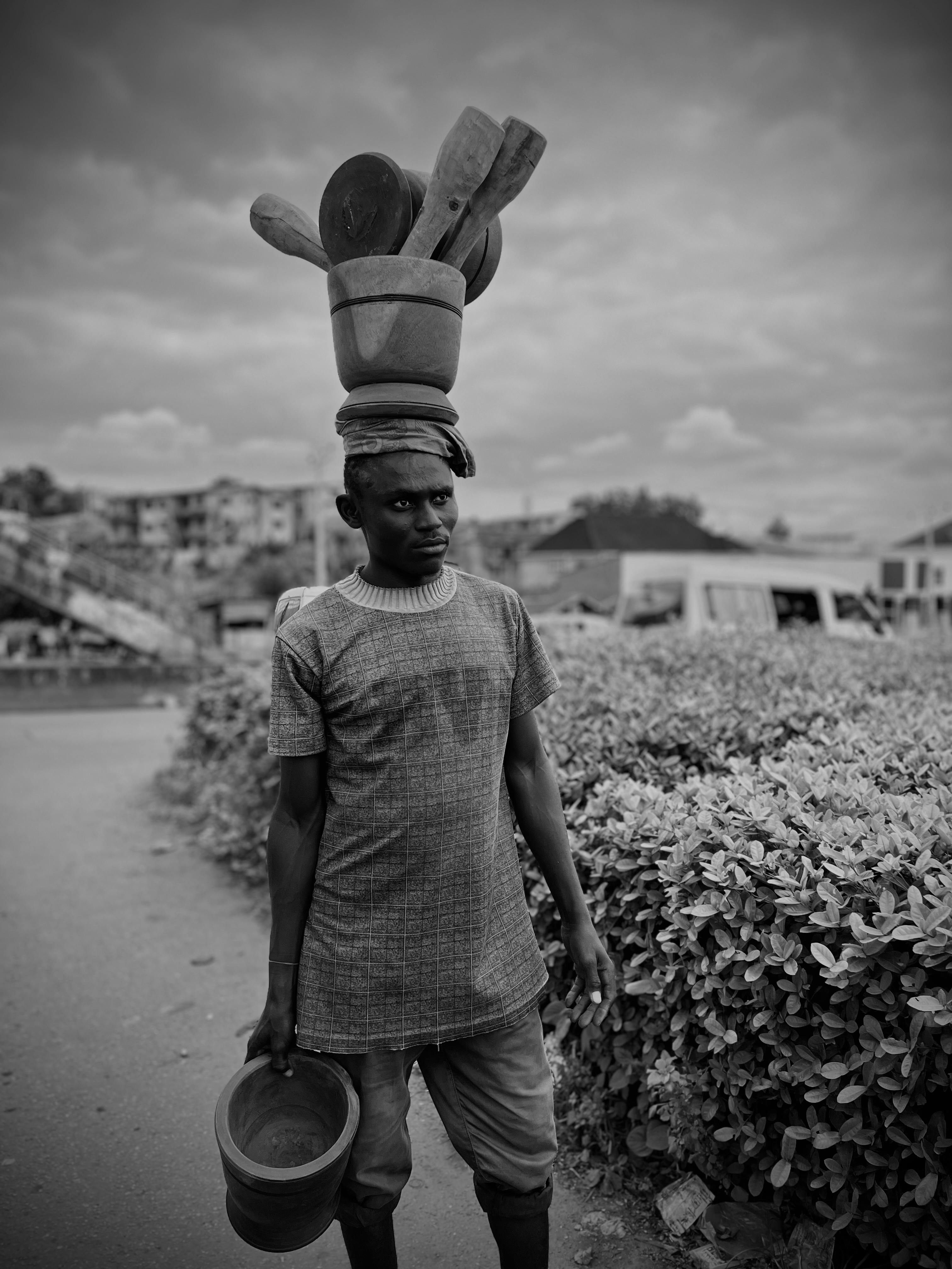 A man carrying pots and pans on his head · Free Stock Photo