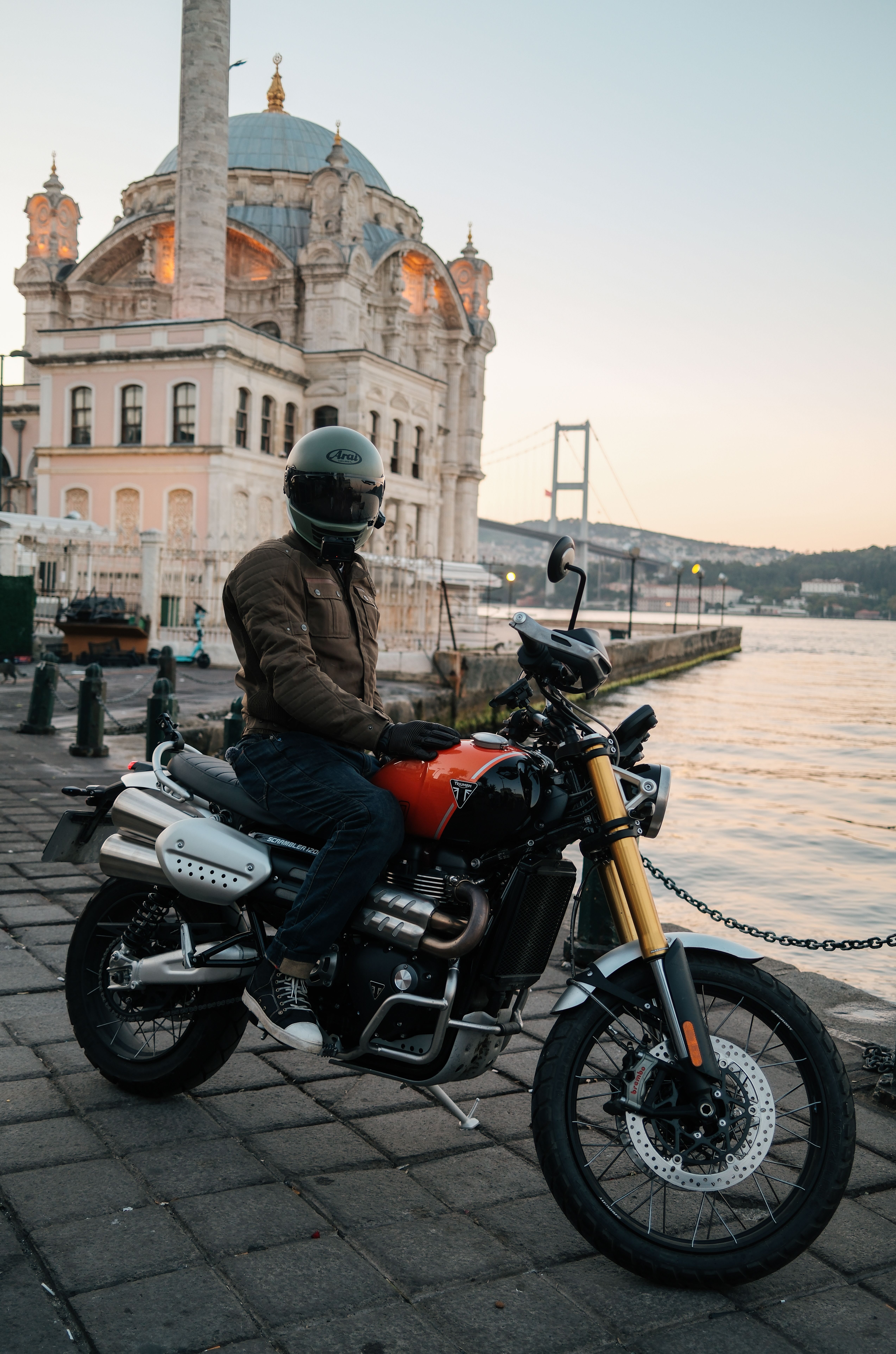 A man is sitting on a motorcycle near a building · Free Stock Photo