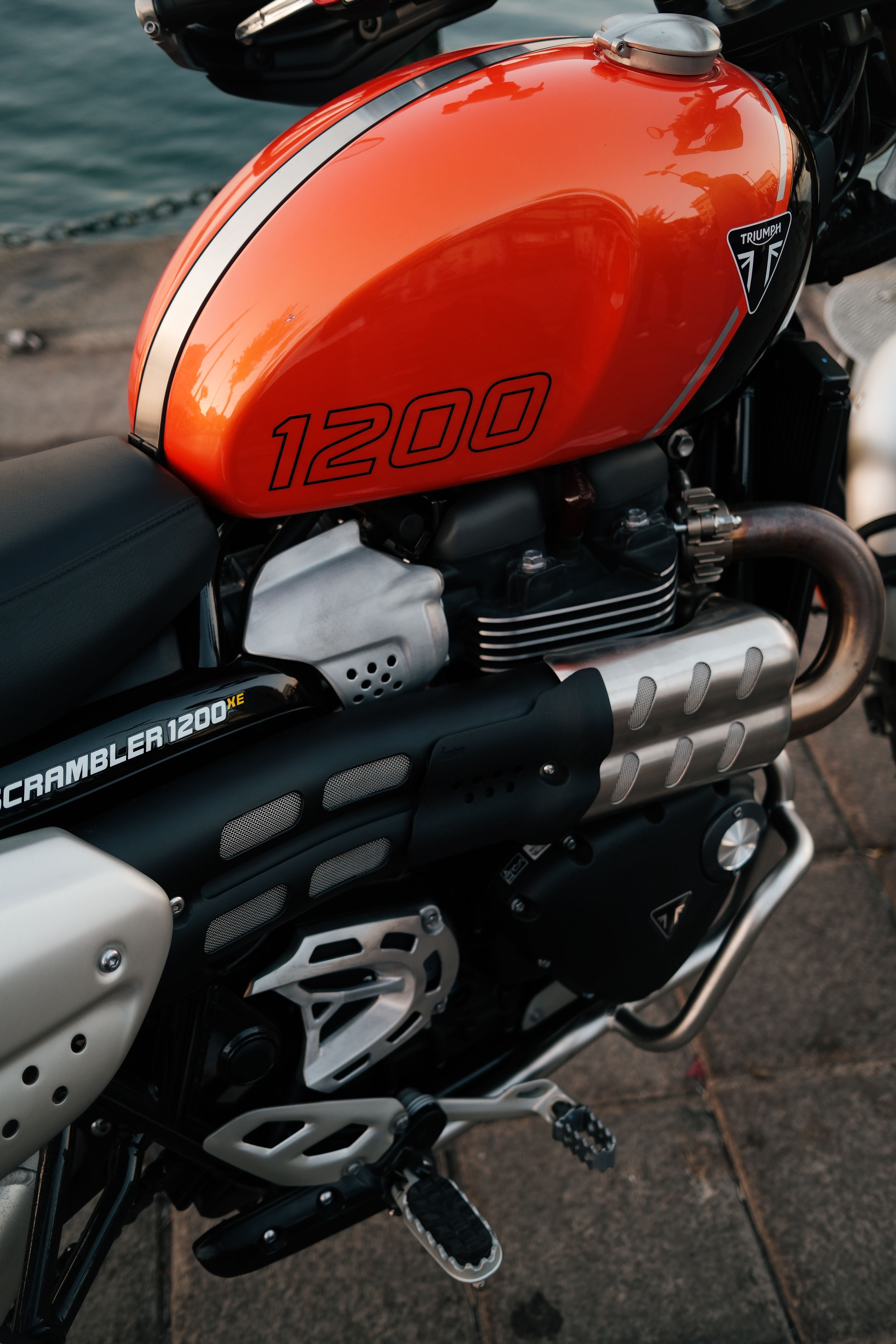 A close up of an orange motorcycle with a red stripe · Free Stock Photo