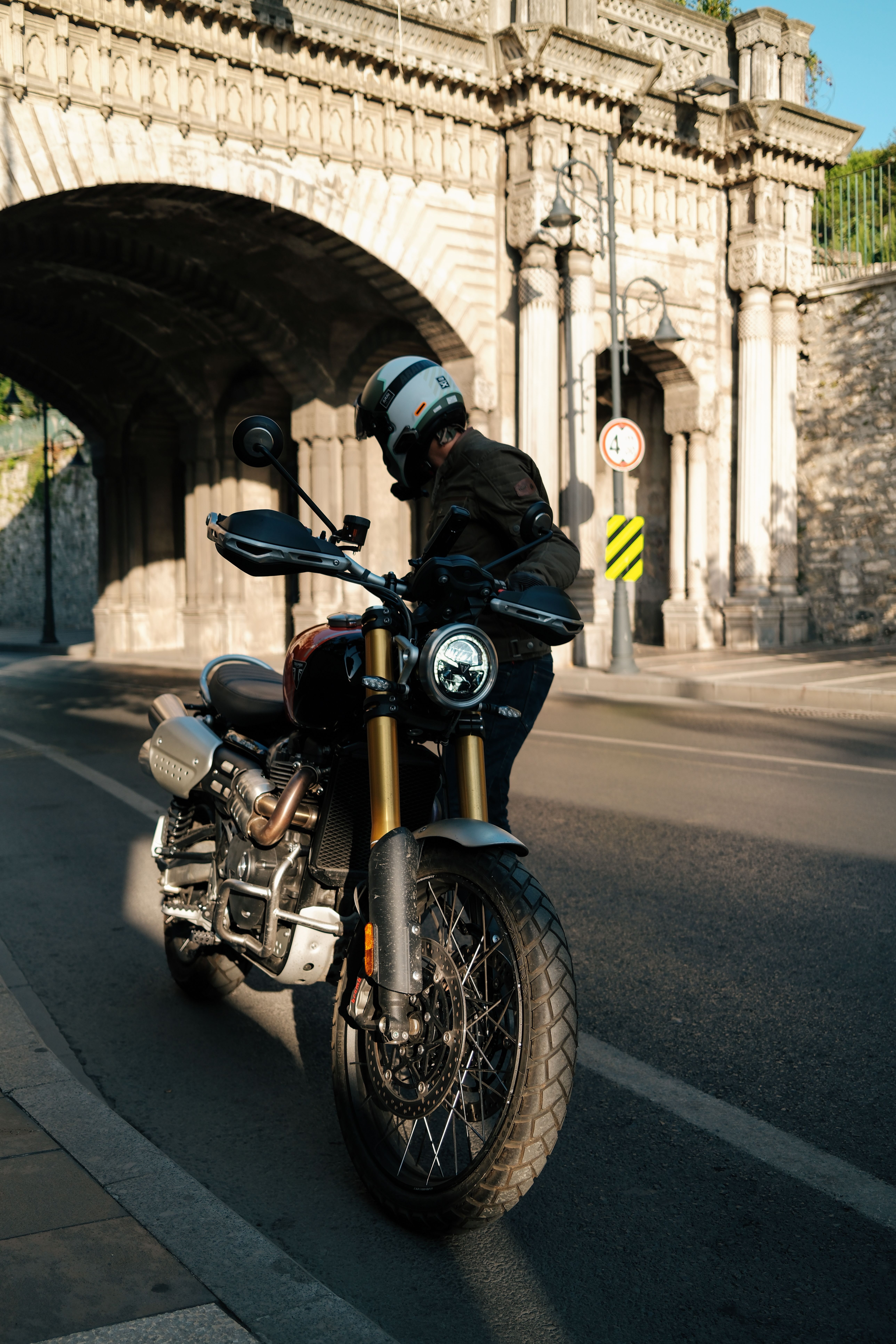 A man on a motorcycle is riding under a bridge · Free Stock Photo