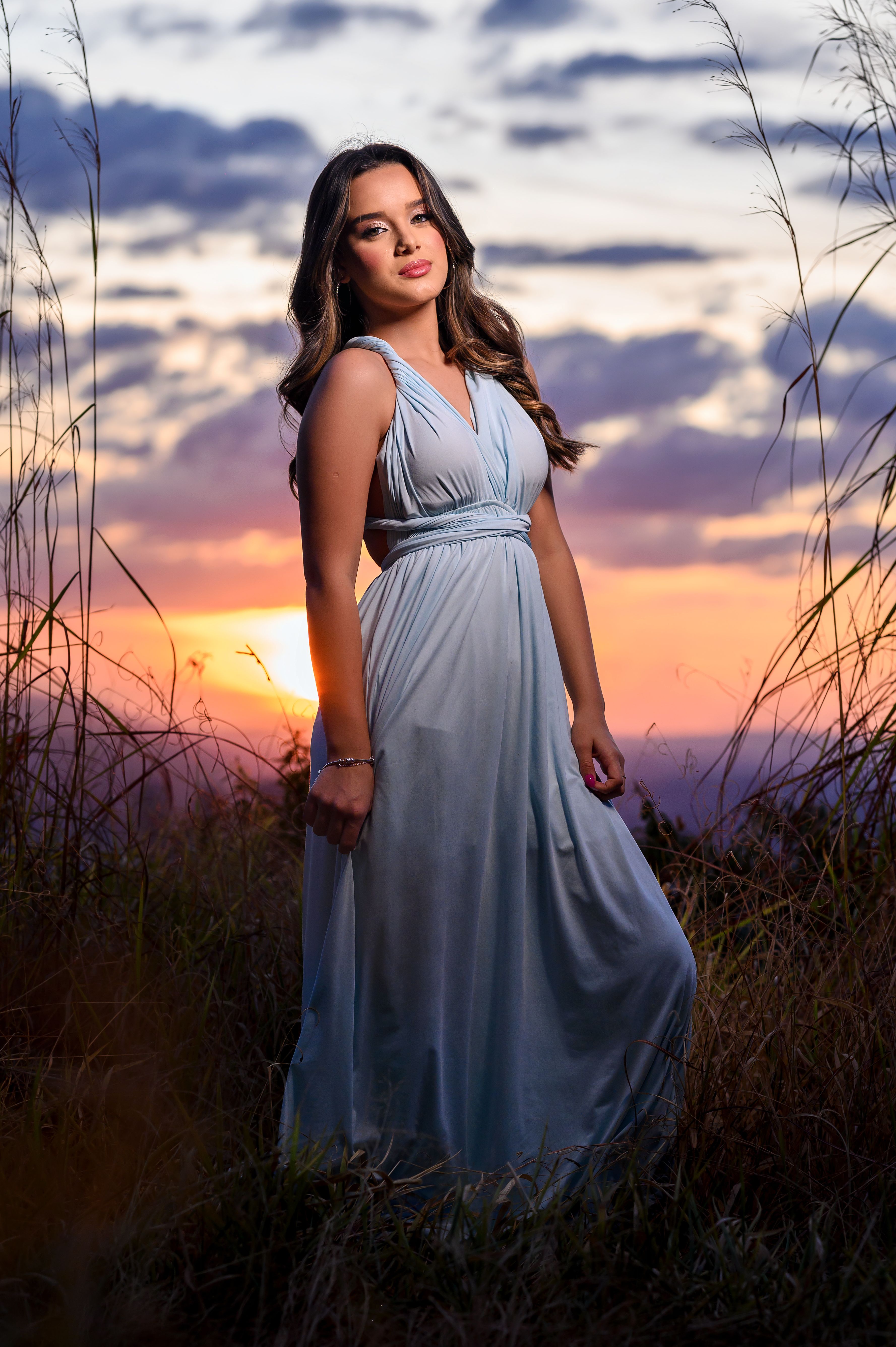 A beautiful young woman in a long dress poses for a sunset photo · Free ...