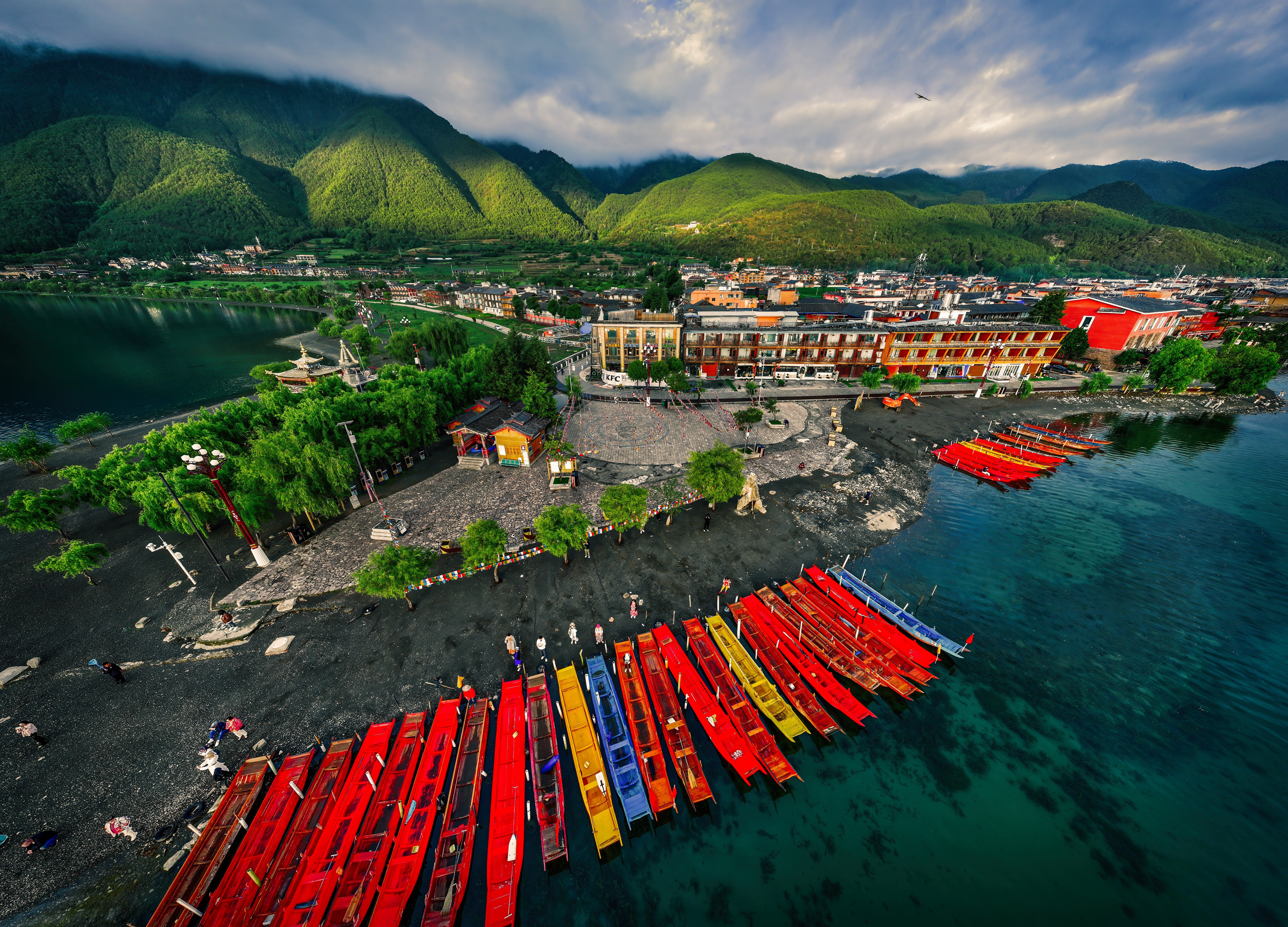 A colorful row of boats in the water near mountains · Free Stock Photo