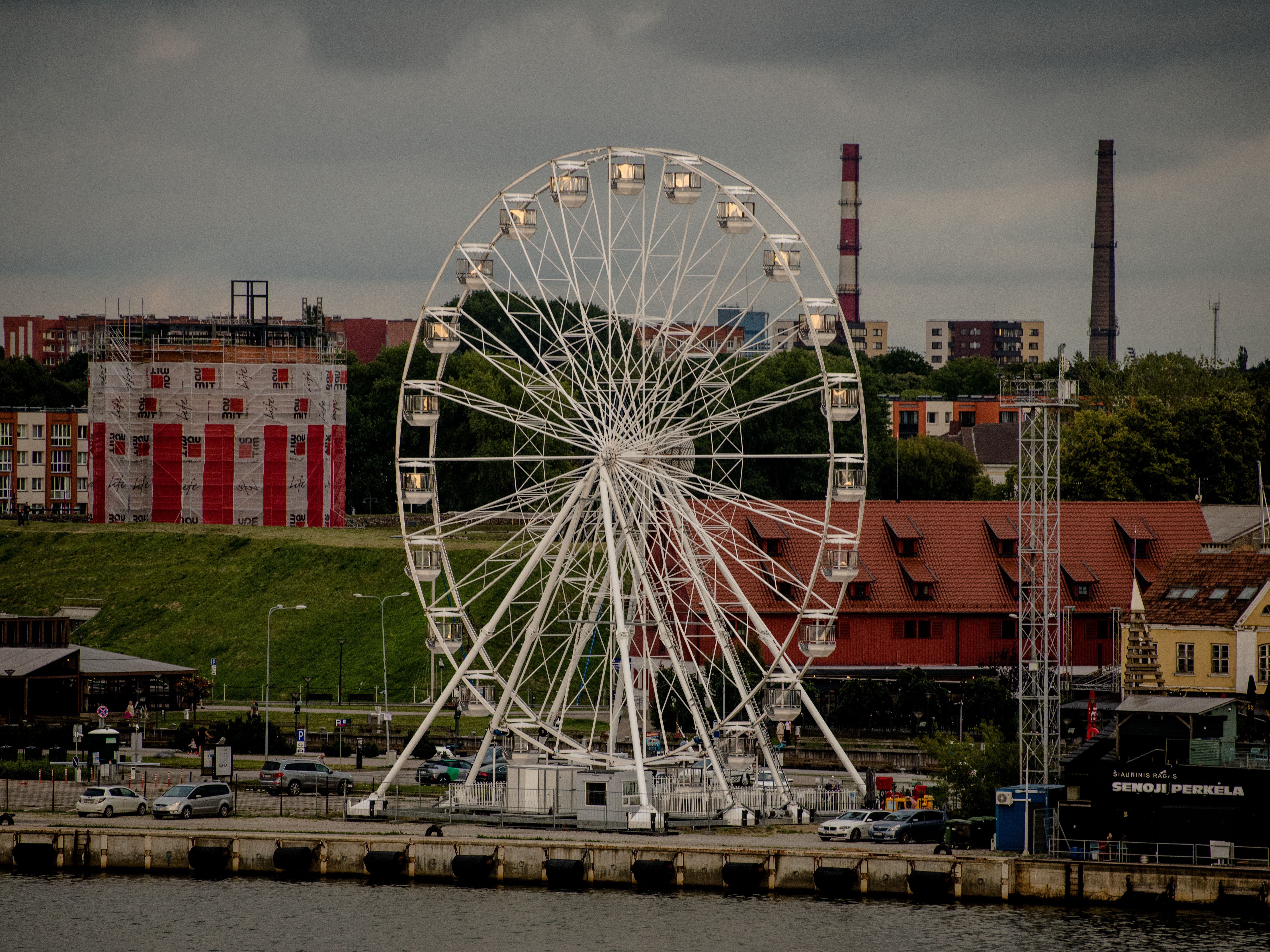 A ferris wheel is sitting in front of a building · Free Stock Photo