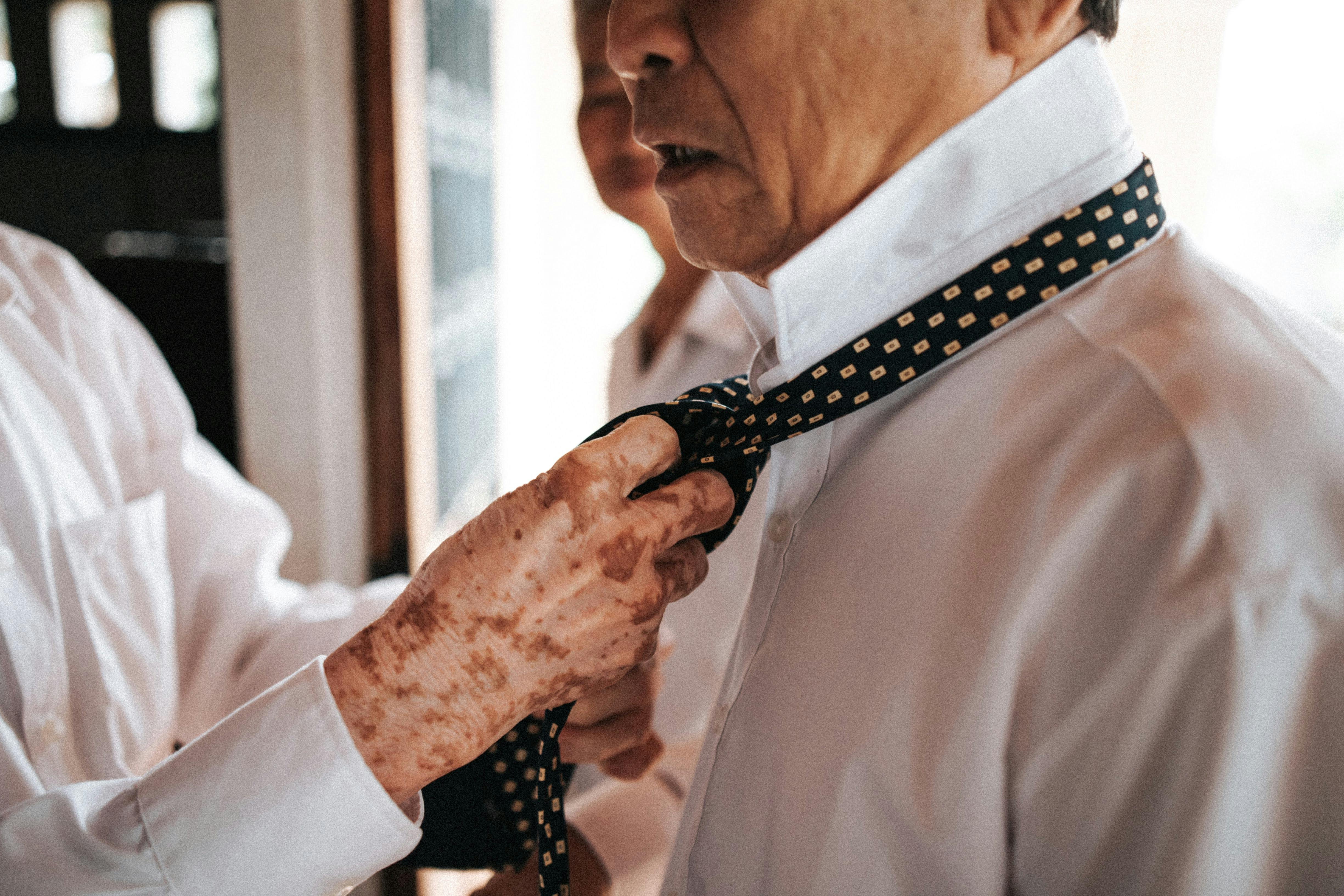 A man tying a tie · Free Stock Photo